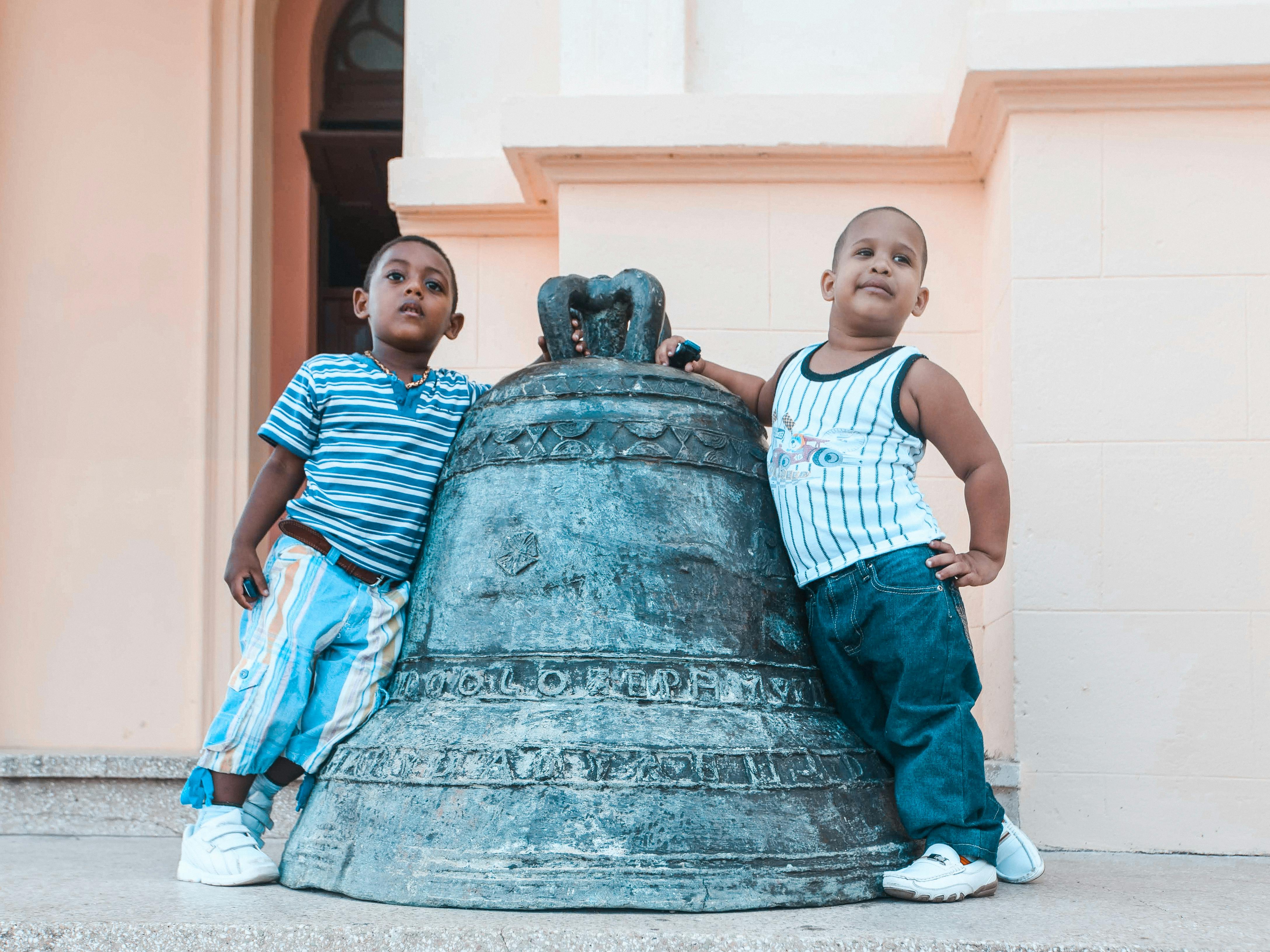 Two Boys Standing with a Bell · Free Stock Photo