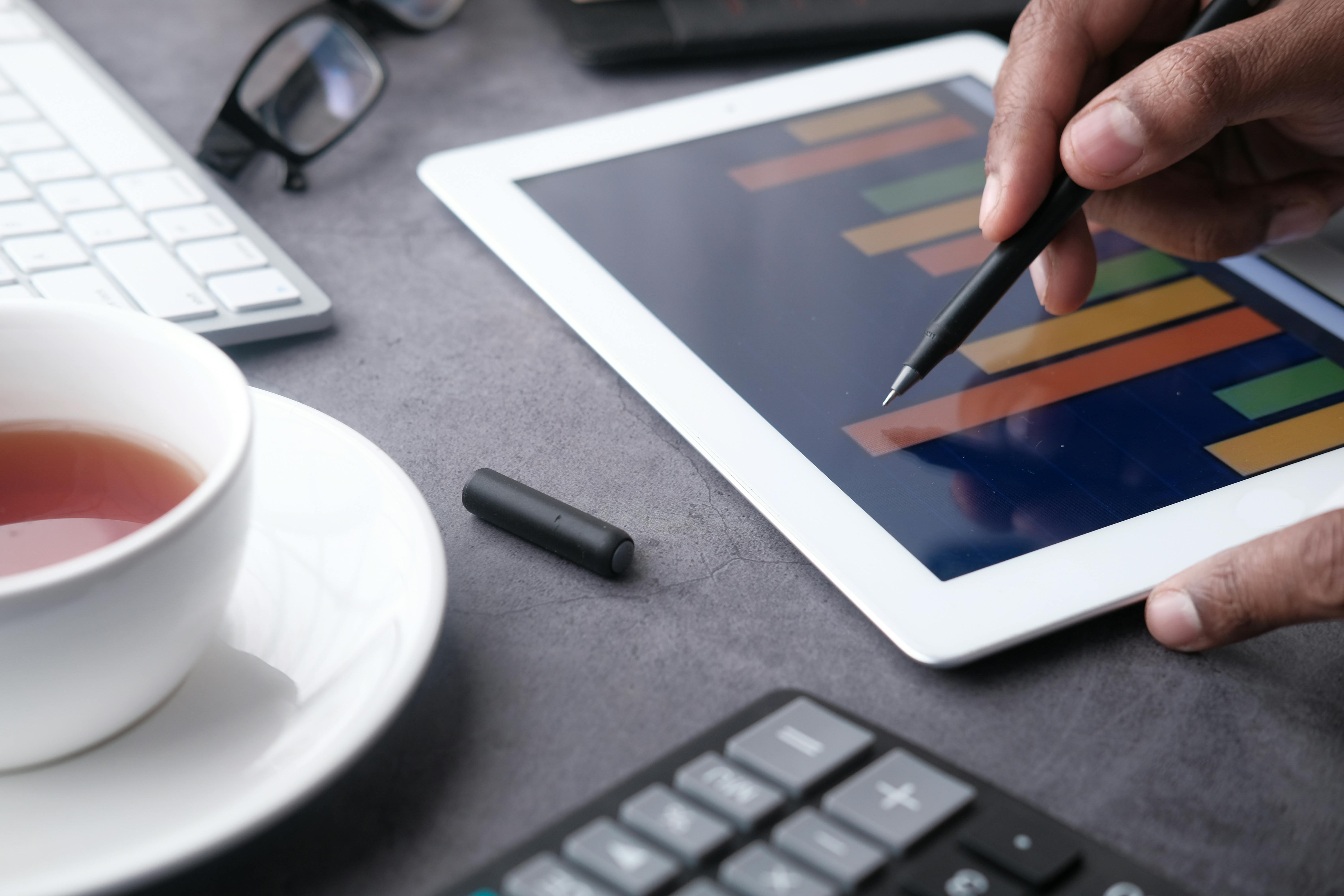 Person Holding a Pen and Pointing at a Screen · Free Stock Photo