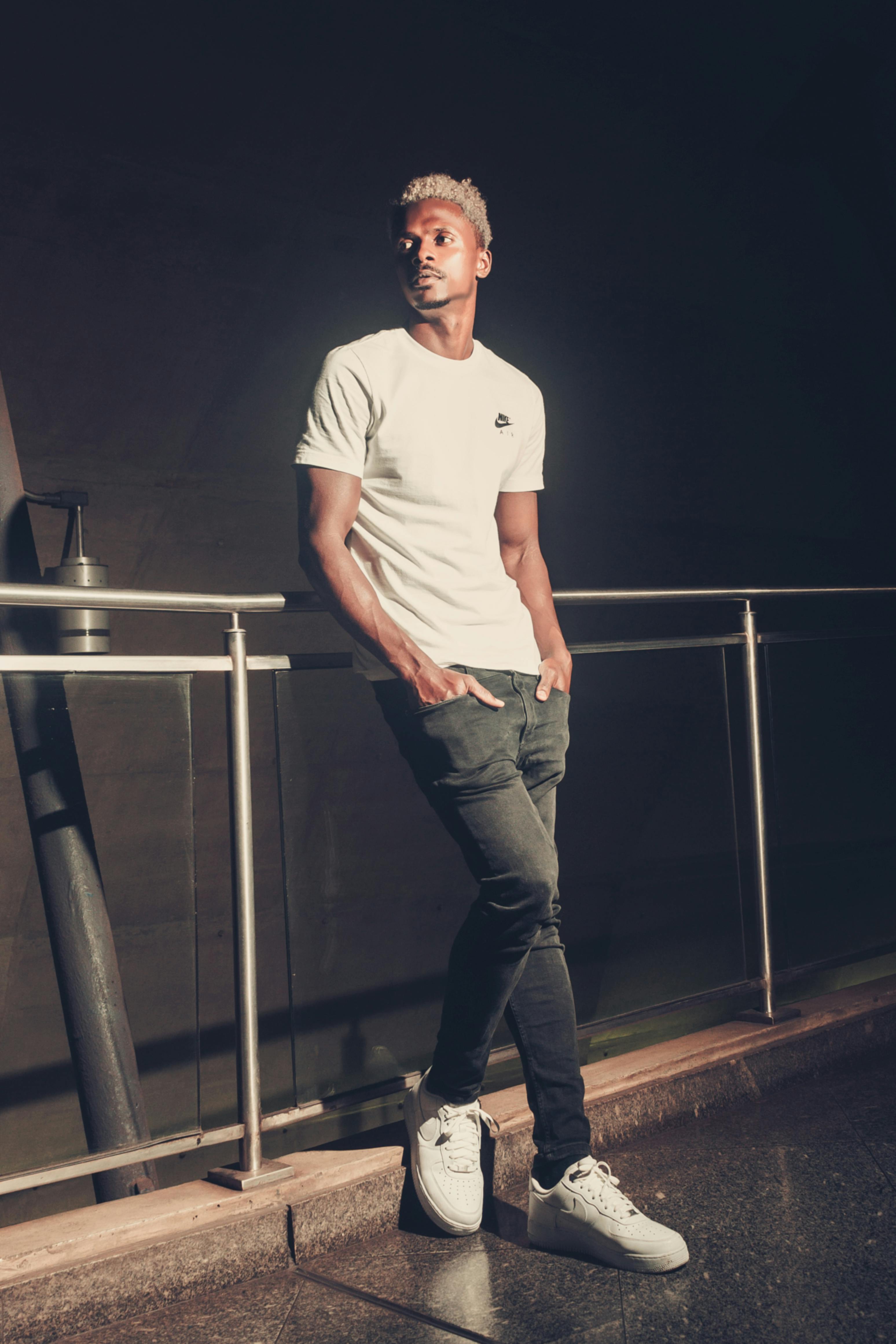 Man Standing While Putting Left Arm on Steel Rod Near Building · Free ...