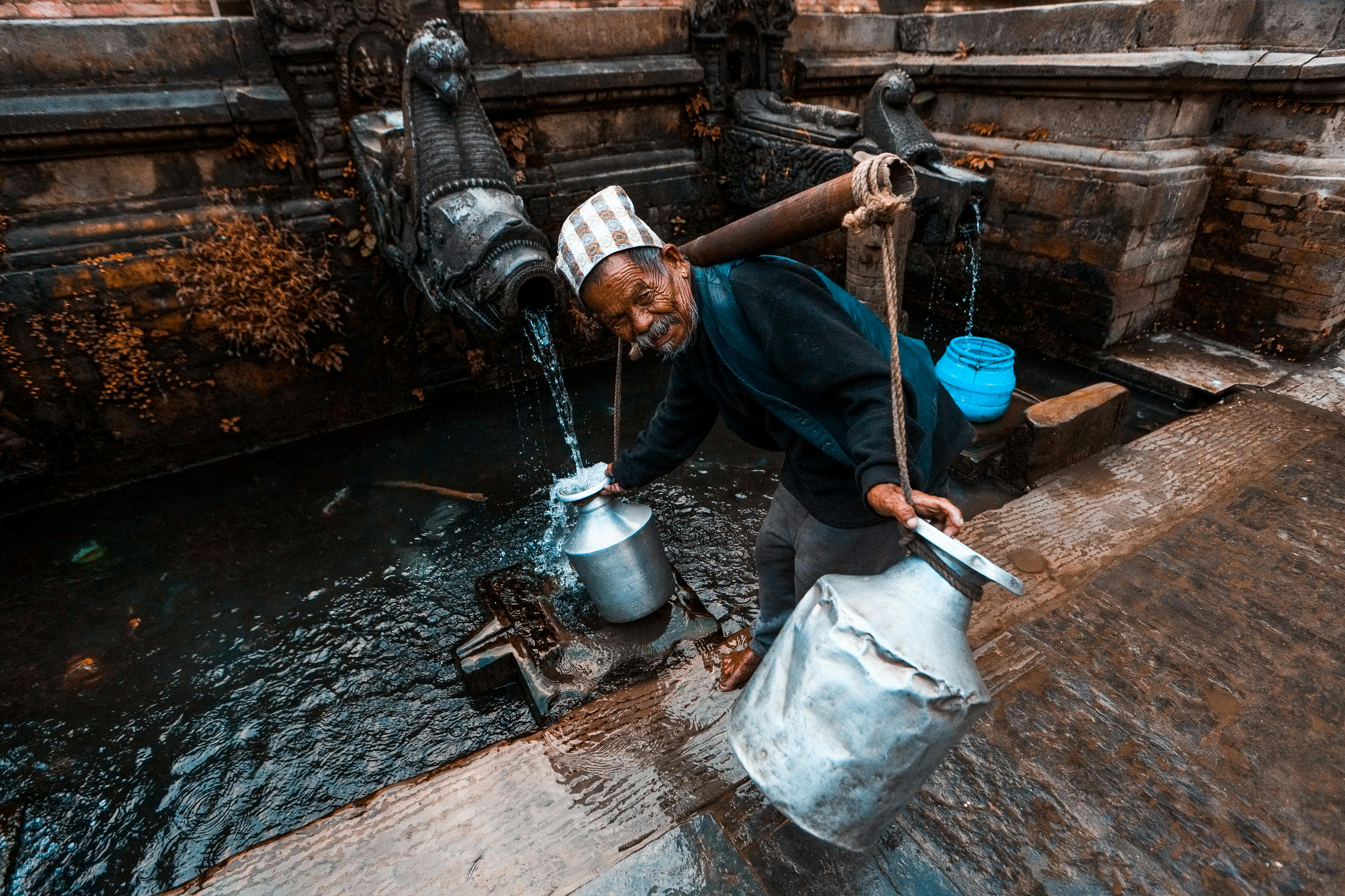 Man Pouring Water from Well · Free Stock Photo