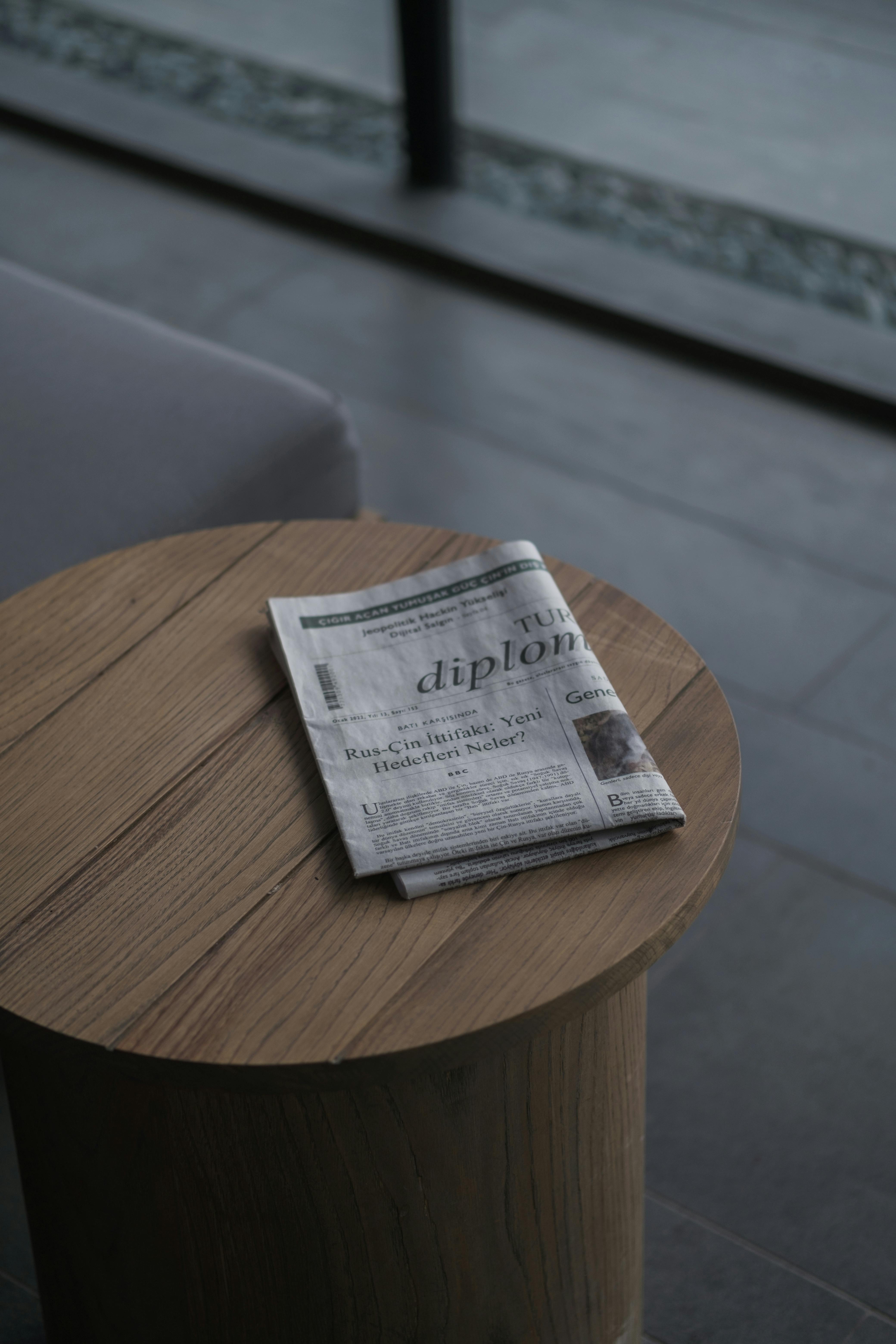 Newspaper on Brown Wooden Round Table · Free Stock Photo