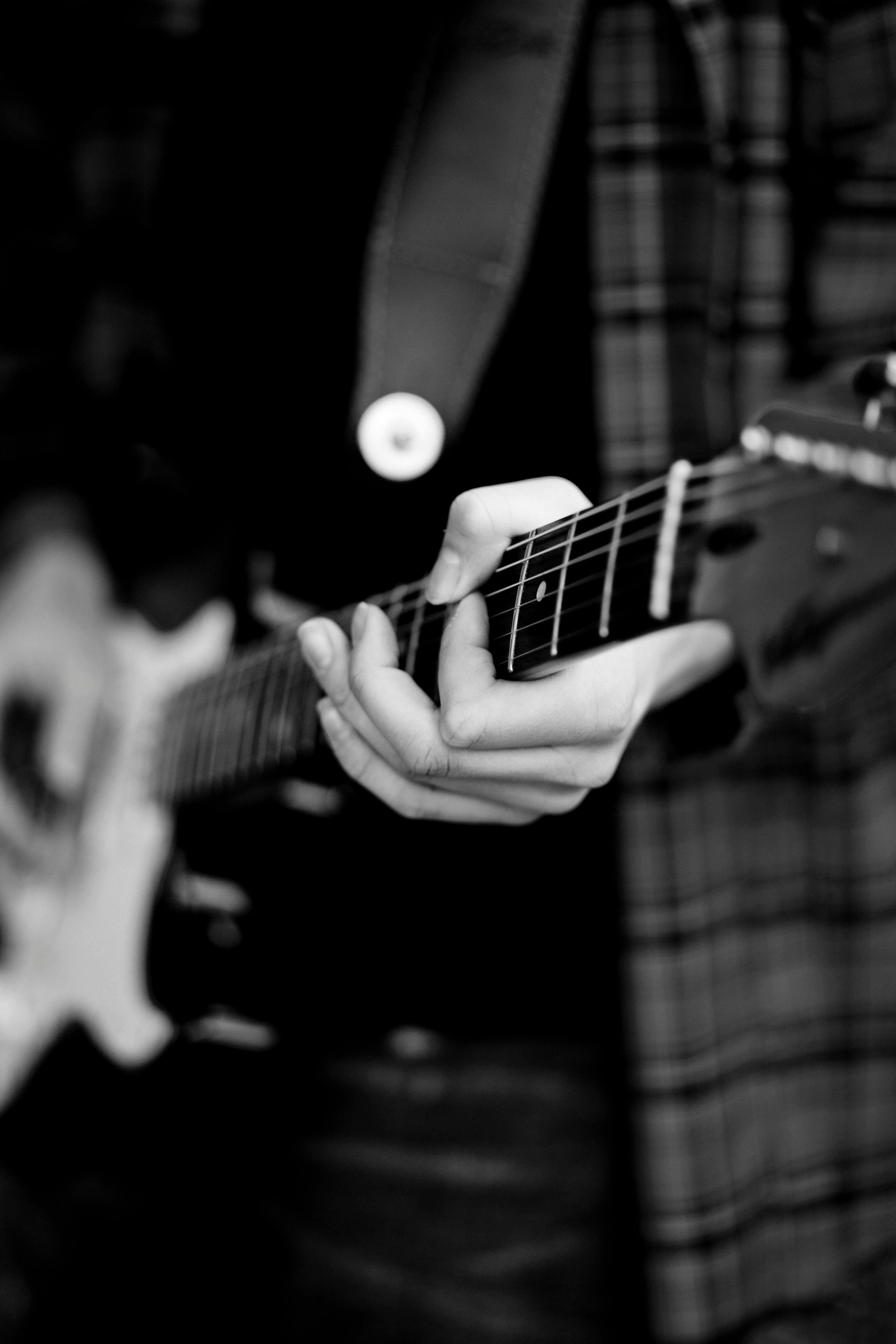Grayscale Photography of Person Playing Electric Guitar · Free Stock Photo