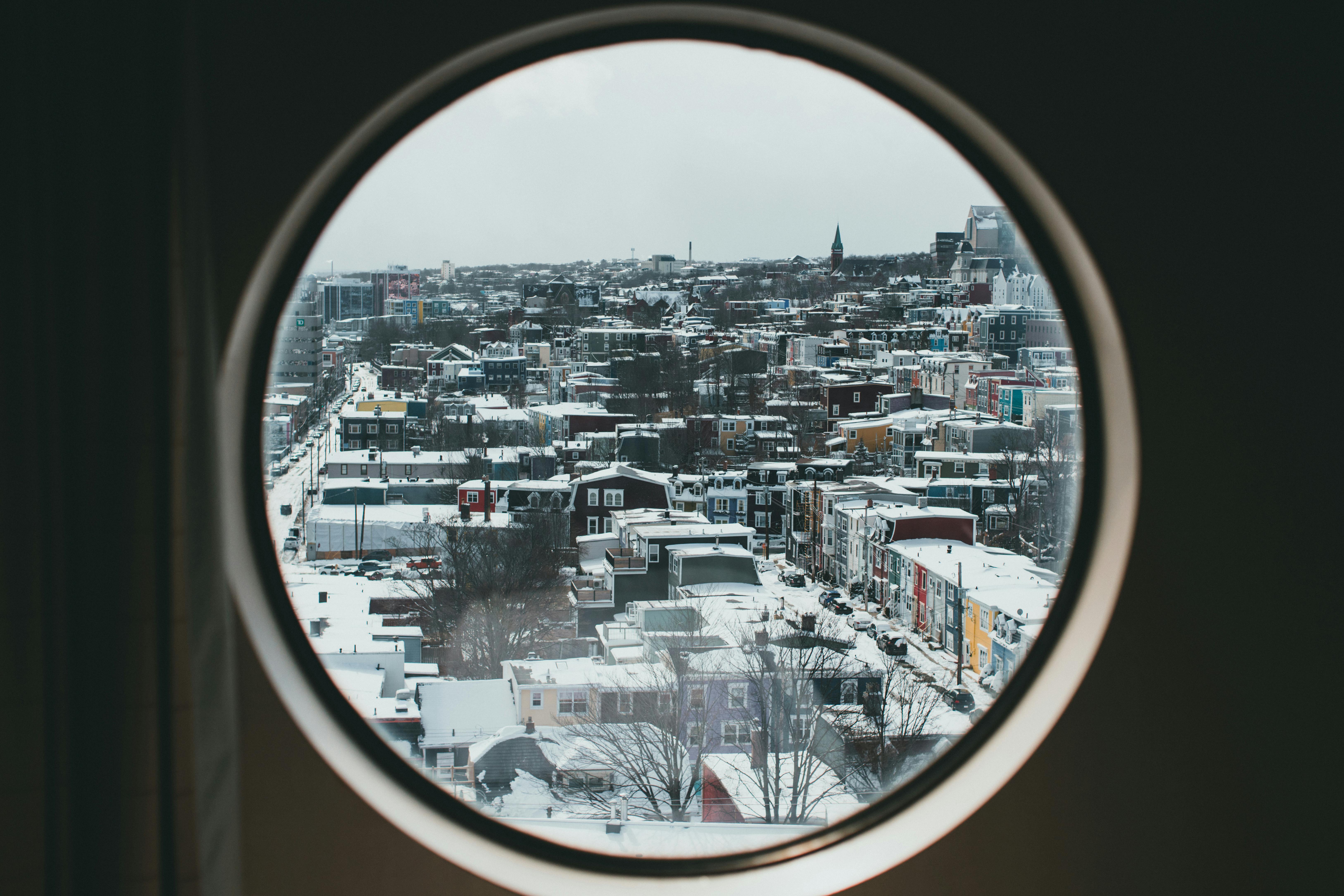 Snow Covered Buildings and Round Glass Window · Free Stock Photo