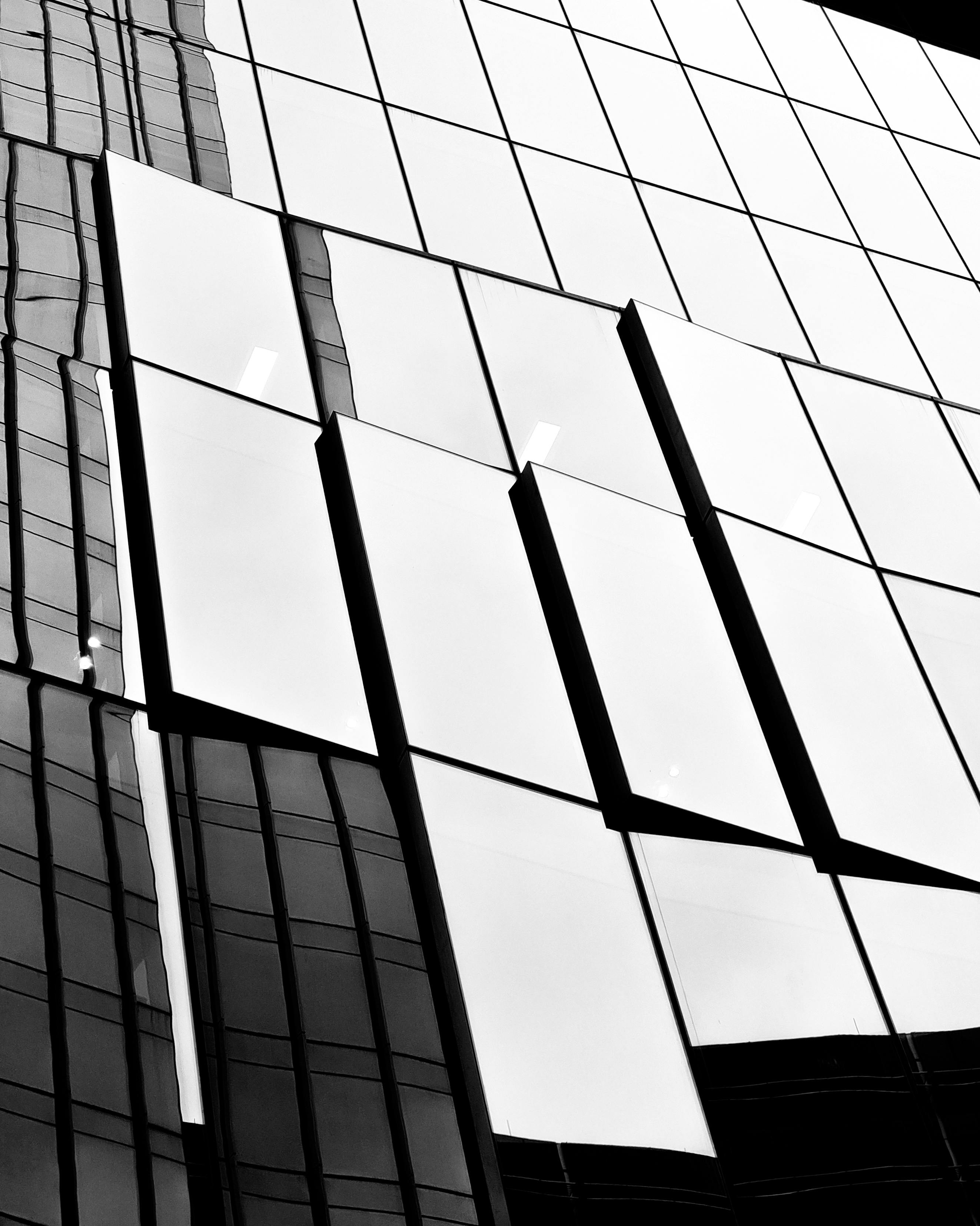 Grayscale Photo of a Glass Building · Free Stock Photo
