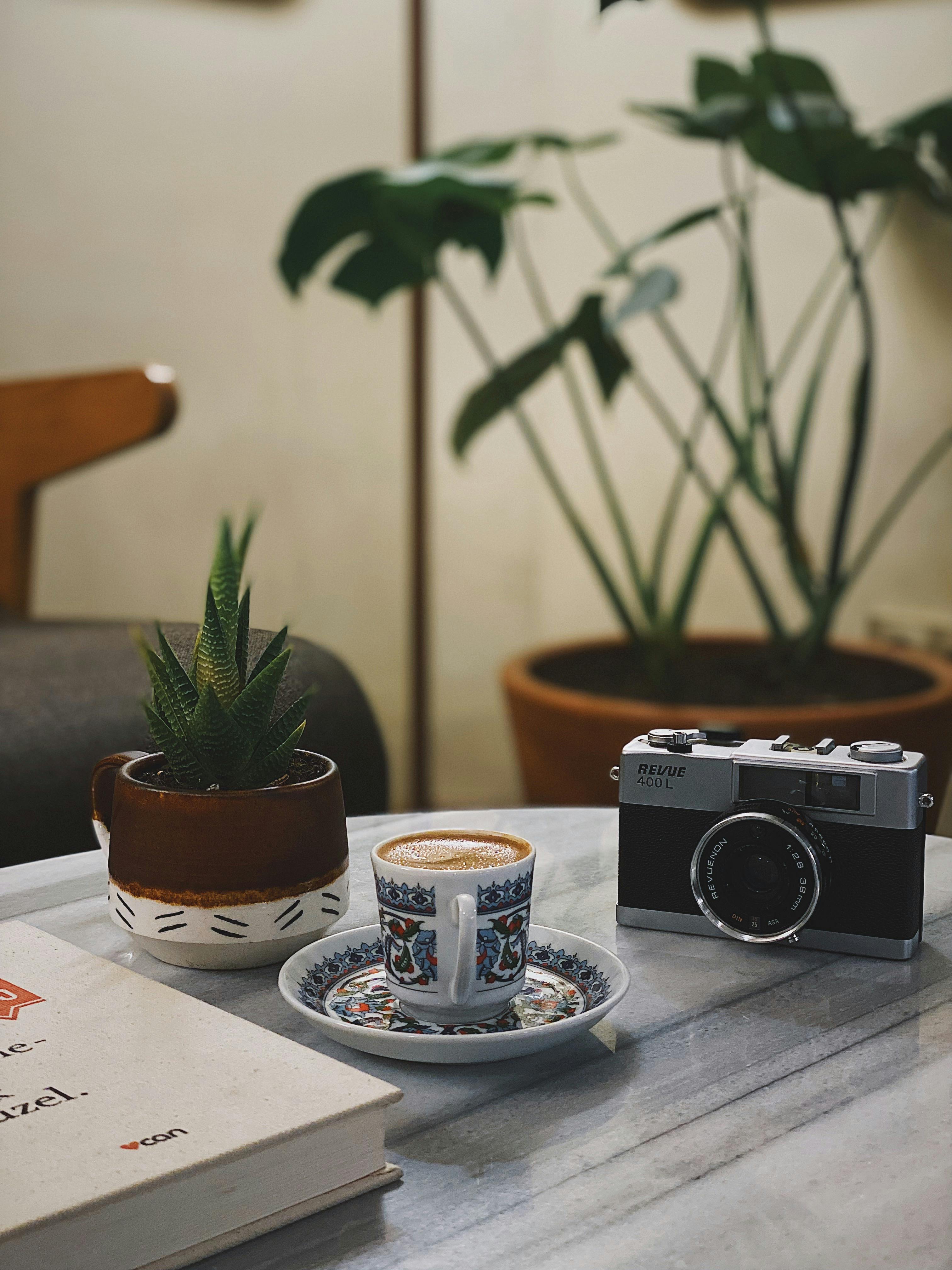 Cup of Coffee and Camera in a Restaurant · Free Stock Photo