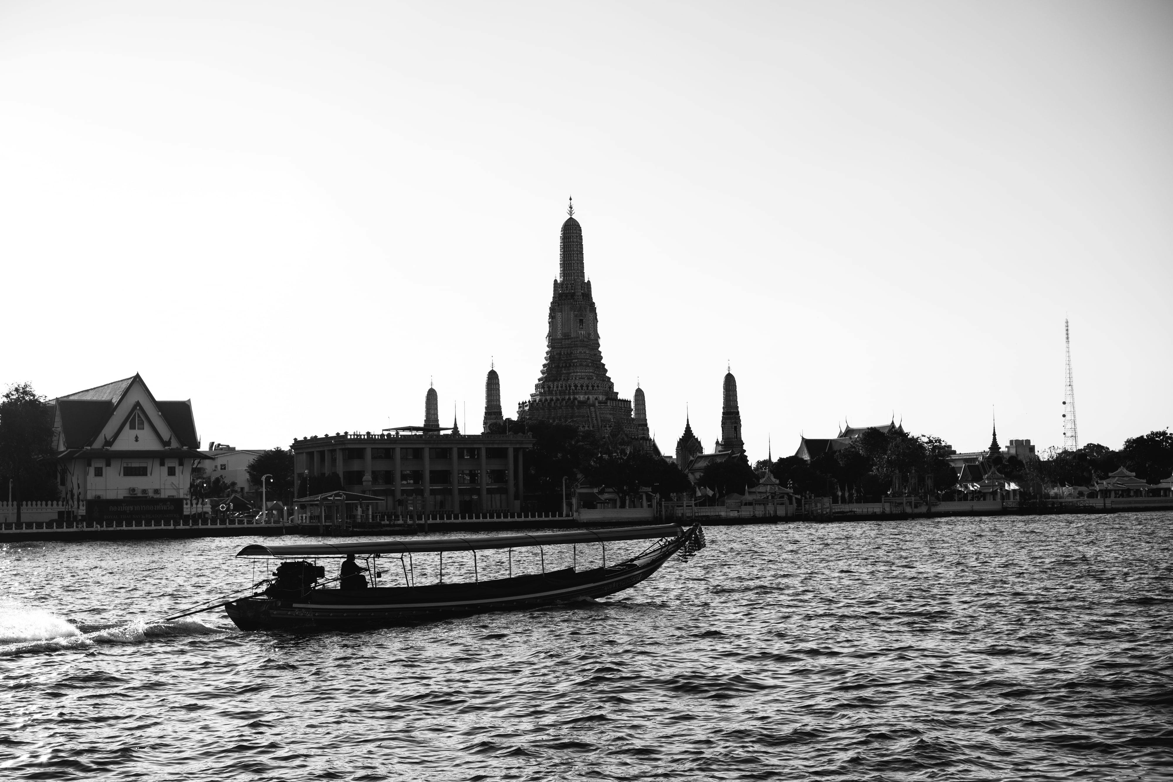 Grayscale Photography of Boat on Water Near Buildings · Free Stock Photo