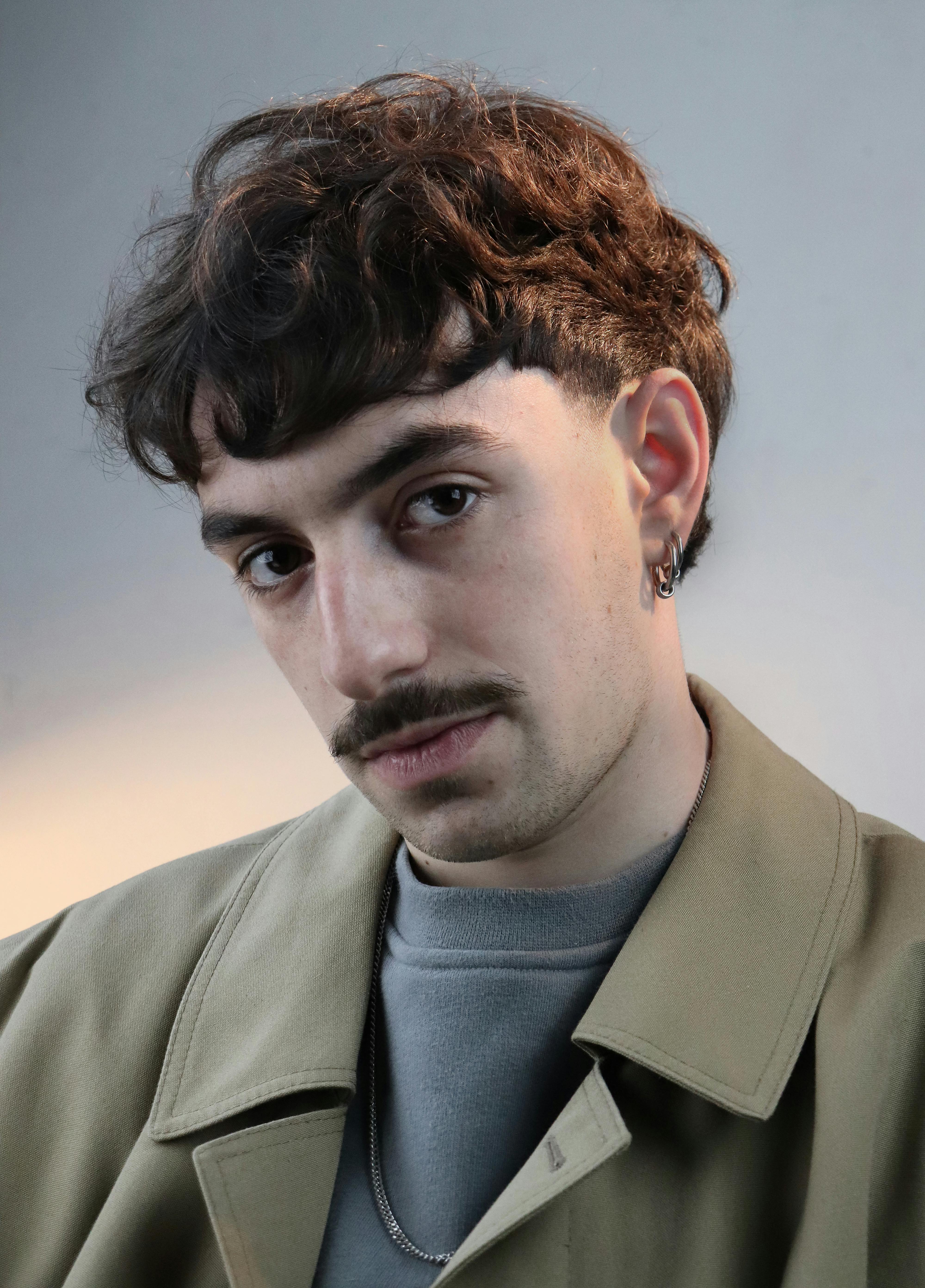 Portrait photo of a Man in white turtleneck t-shirt with red string on ...