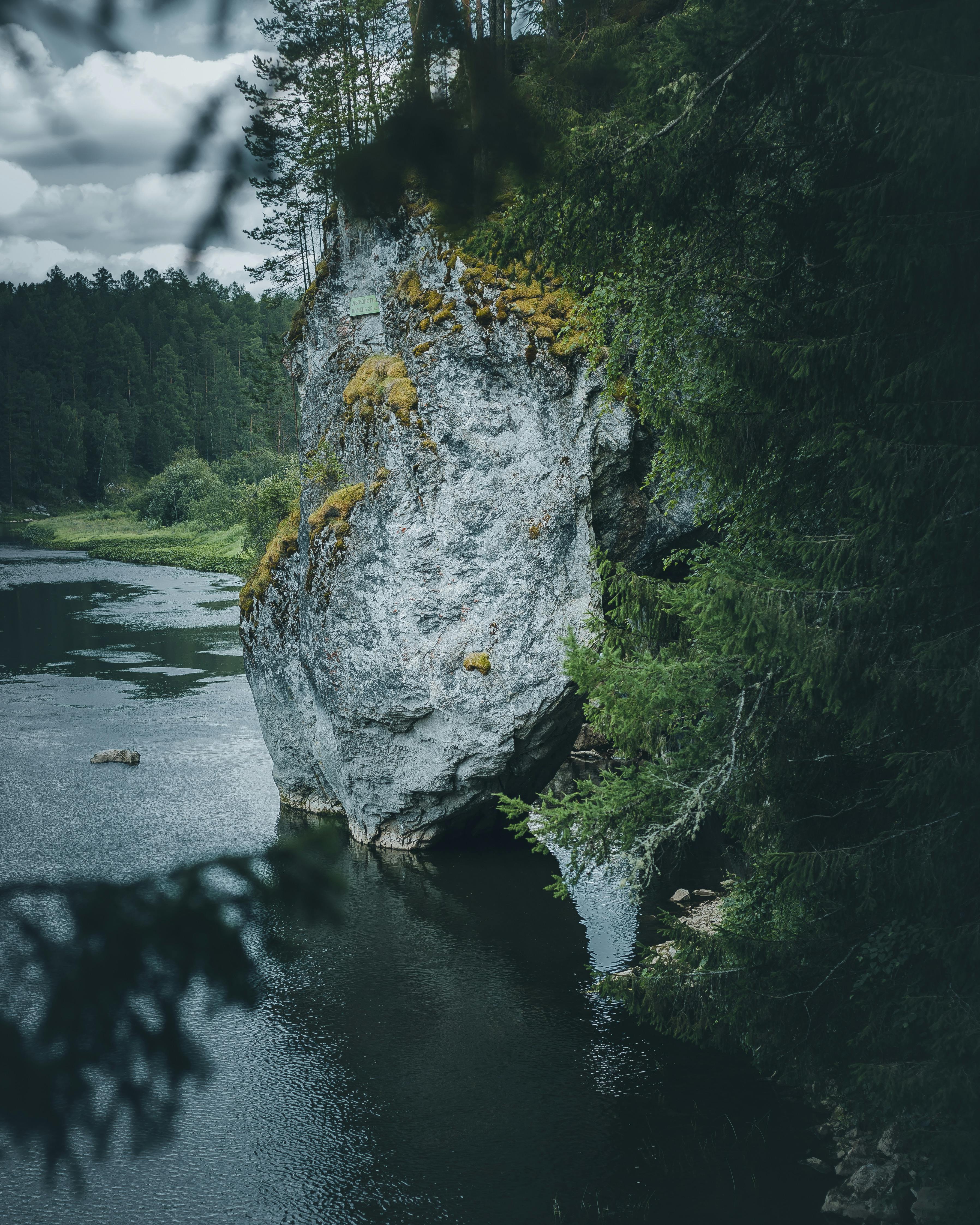 Gray Rocky Cliff Beside Body of Water · Free Stock Photo
