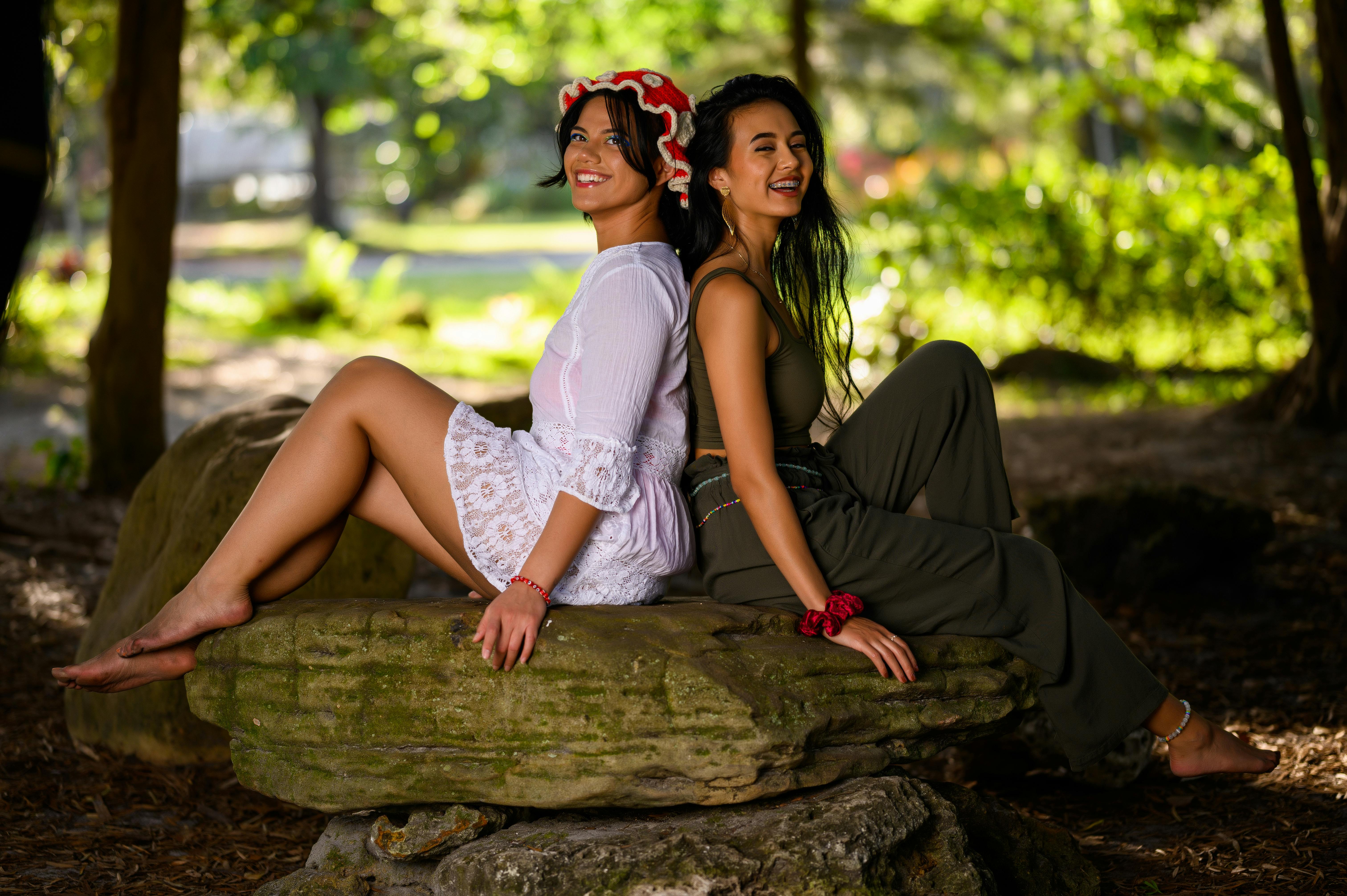 Smiling Women Sitting on a Big Rock · Free Stock Photo