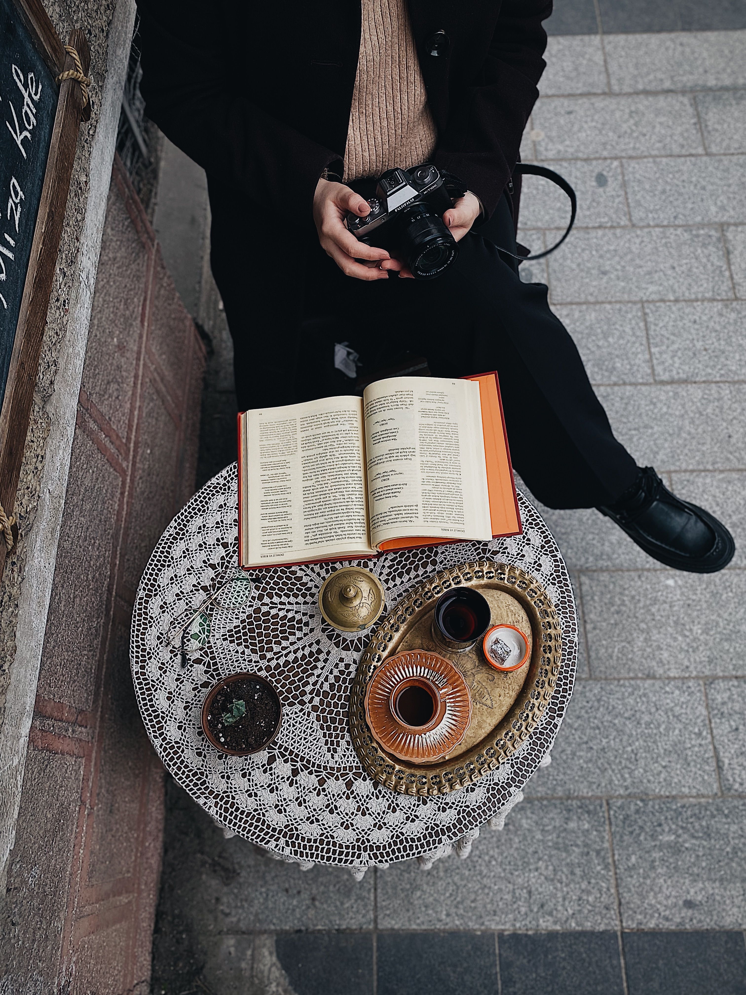 Person Sitting Beside an Open Book · Free Stock Photo