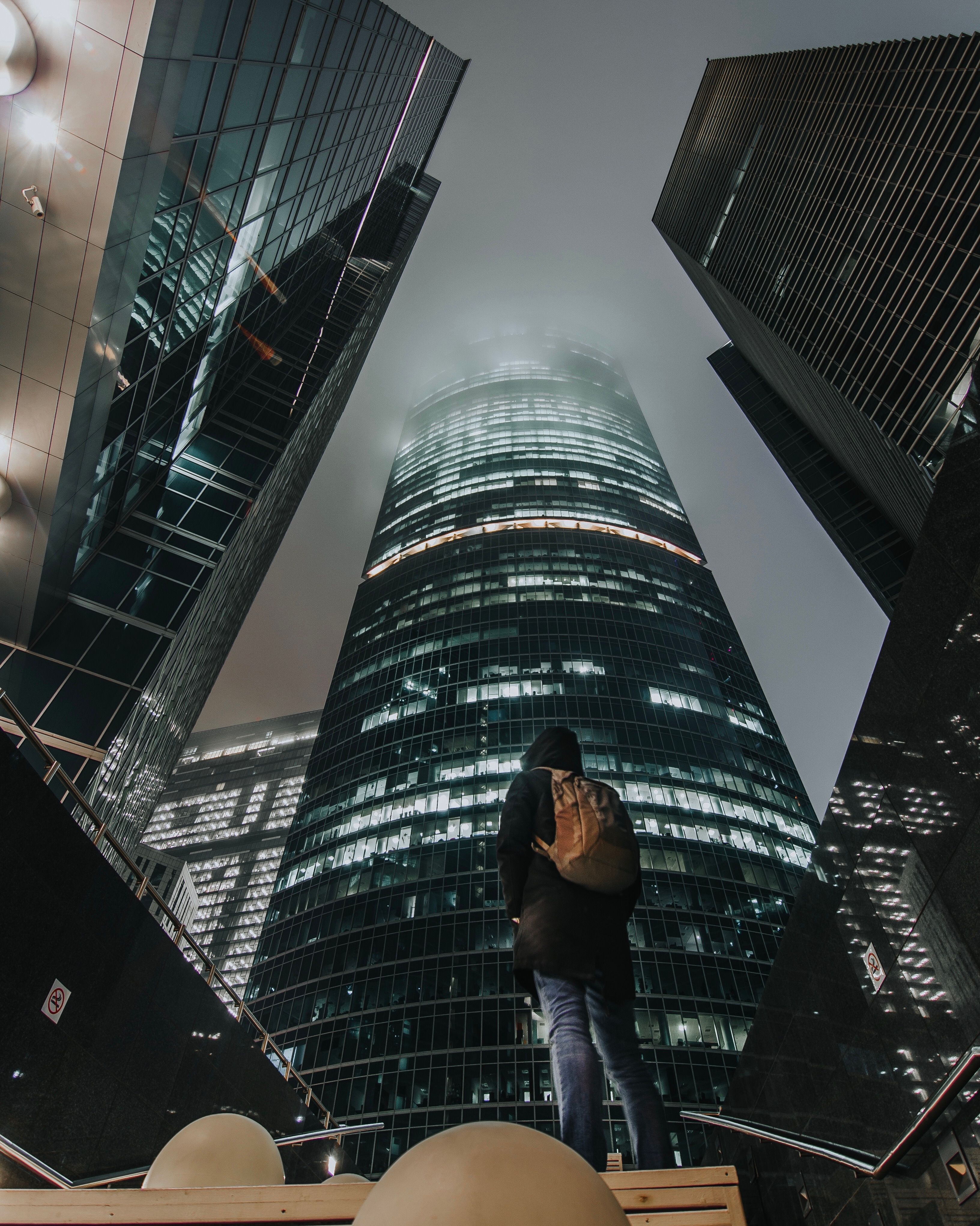 Man Standing Beside Tall Buildings · Free Stock Photo