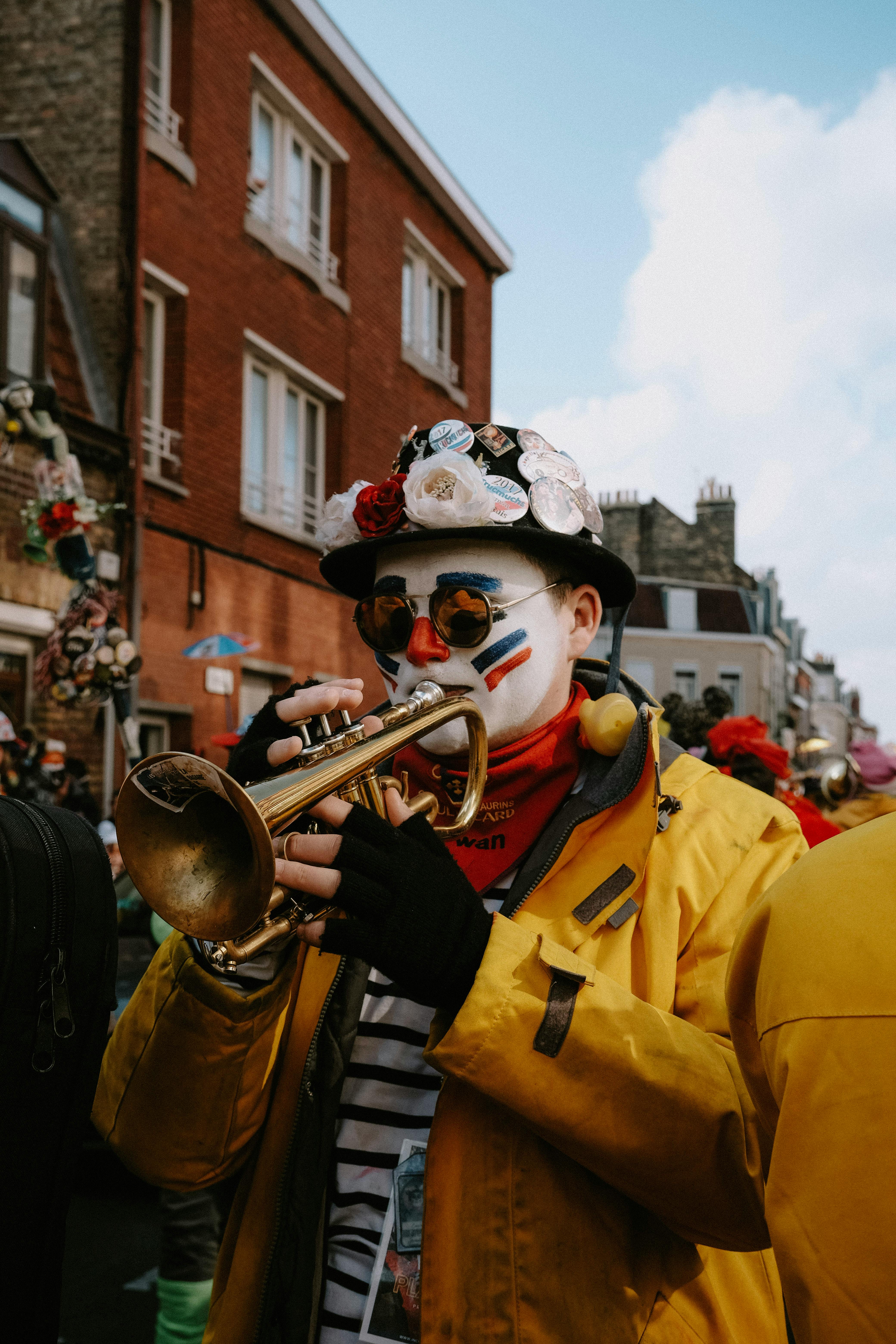 Man in Clown Costume Playing Trumpet in Street Parade · Free Stock Photo