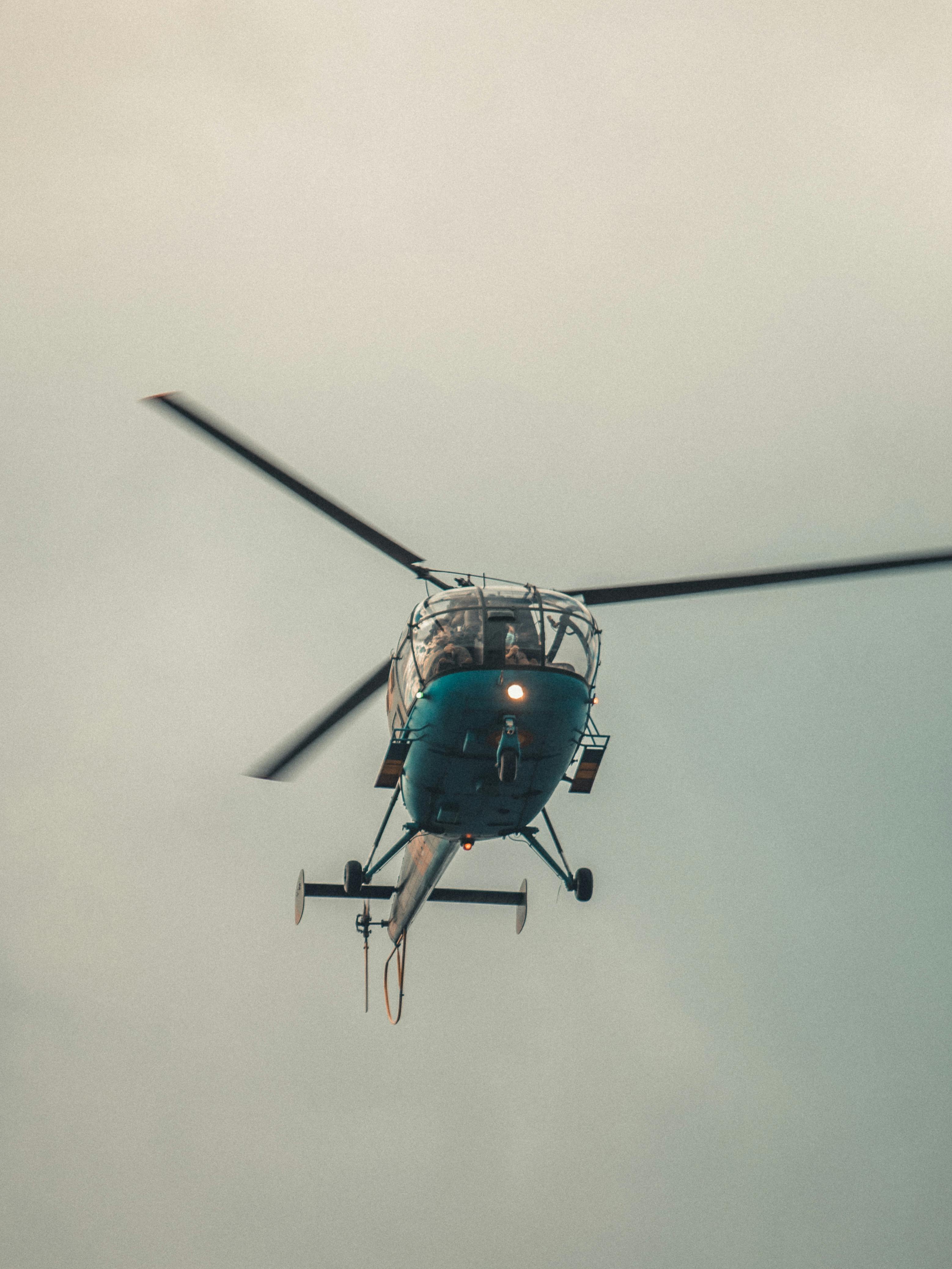 Brown Helicopter Flying Above Green Field during Daytime · Free Stock Photo