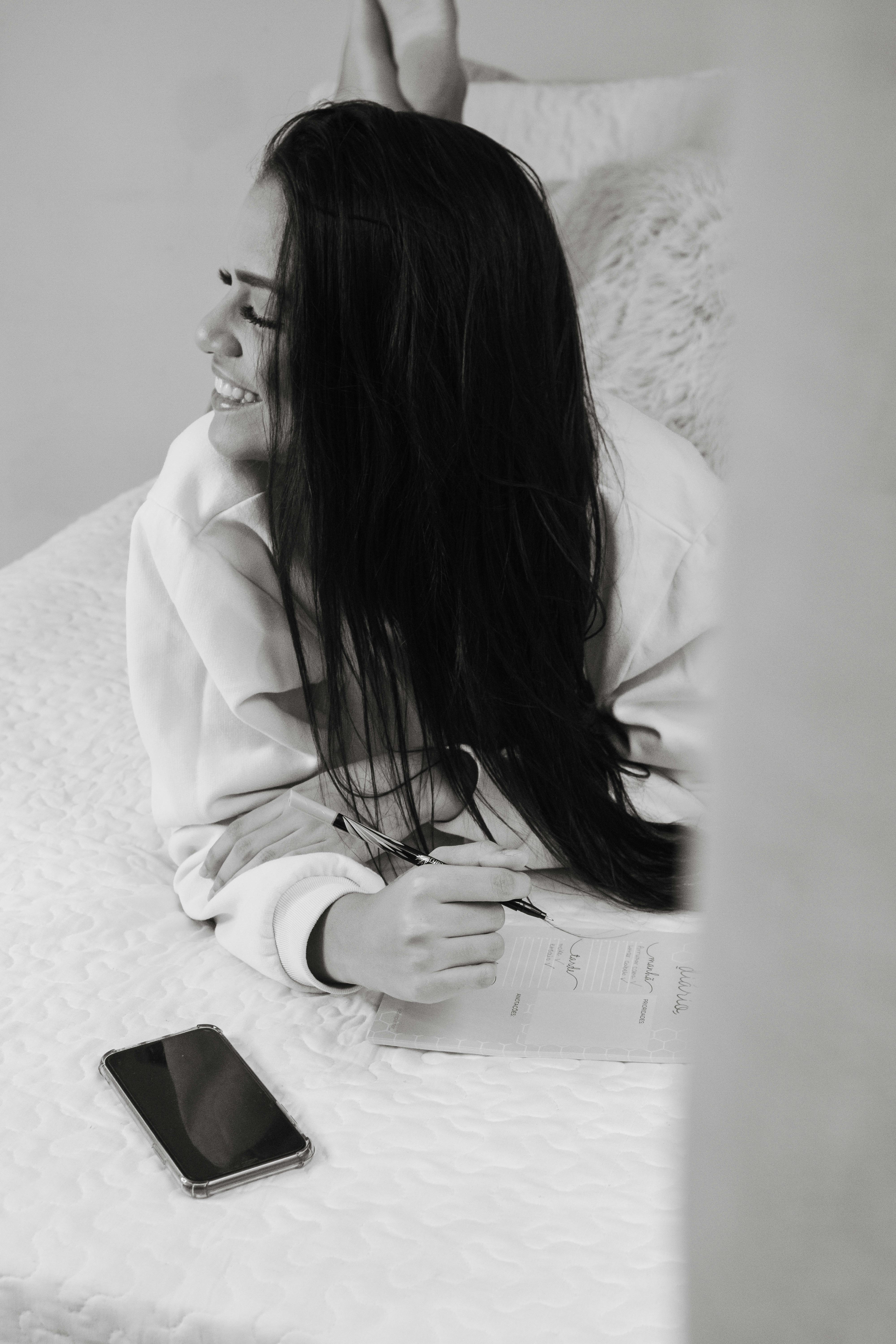 Woman in White Robe Writing on the Bed · Free Stock Photo
