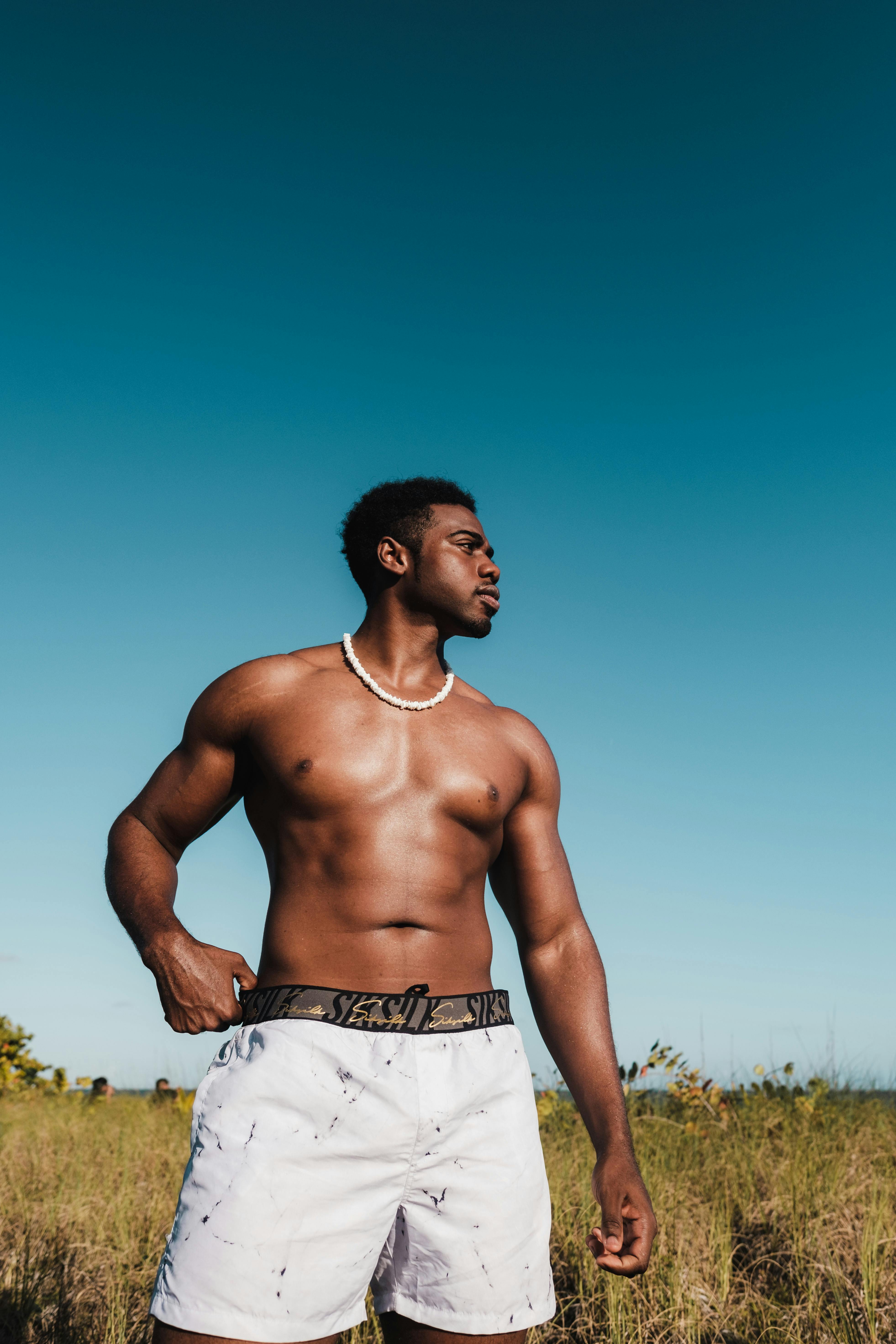 A Shirtless Man Carrying a Concrete Block on His Back · Free Stock Photo