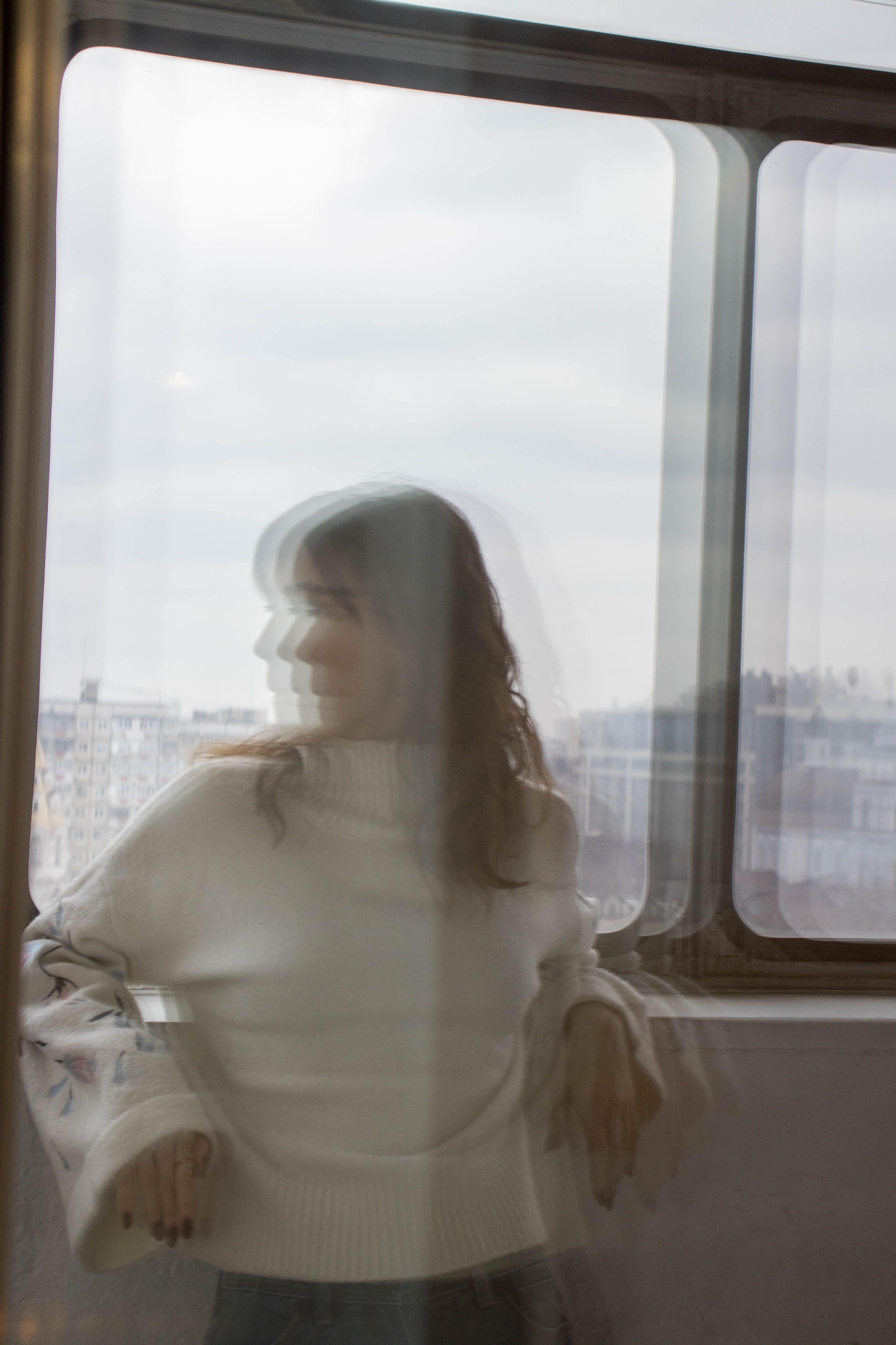 A Woman Standing by a Window · Free Stock Photo