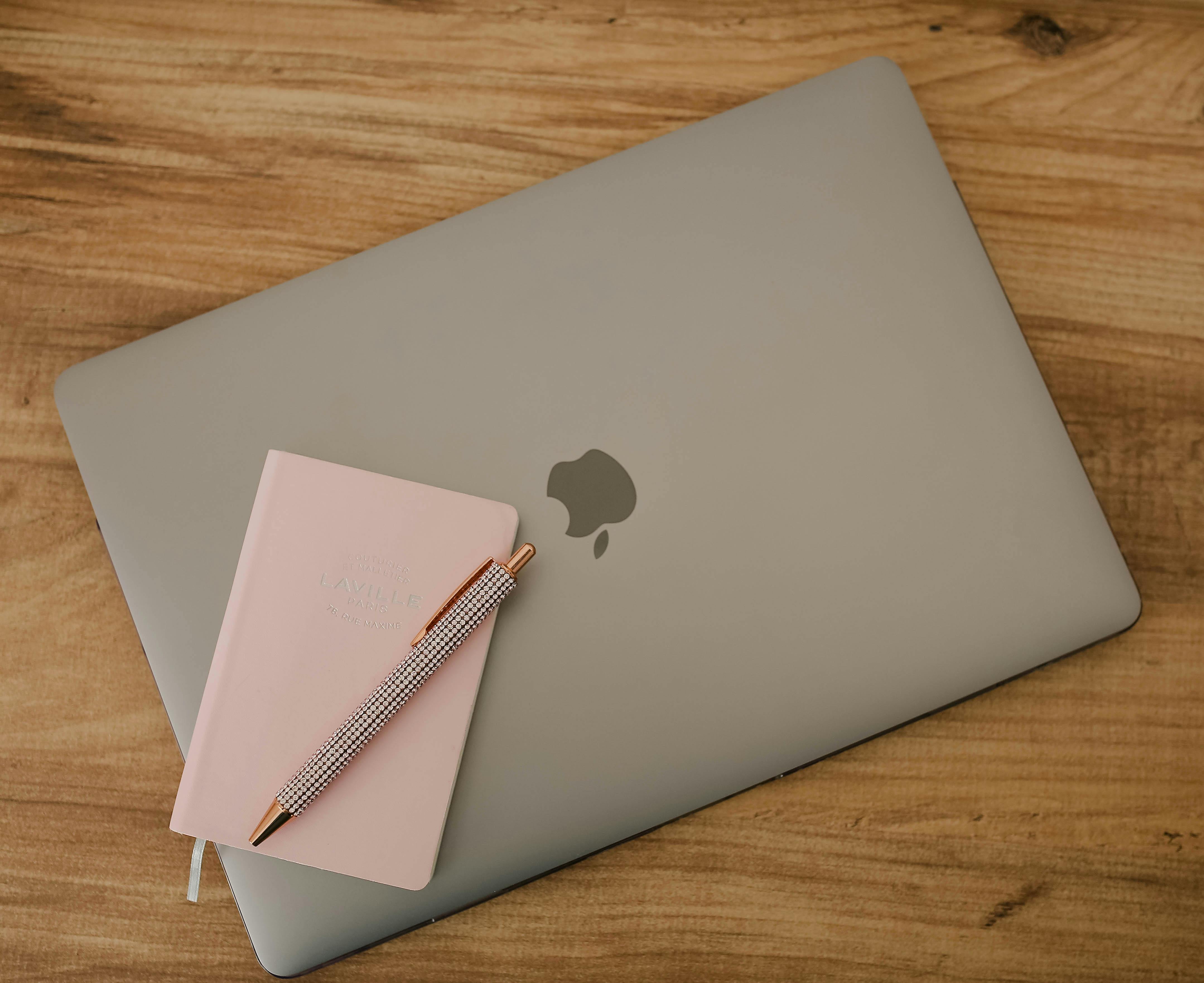 Pink Notebook on Top of a Laptop · Free Stock Photo