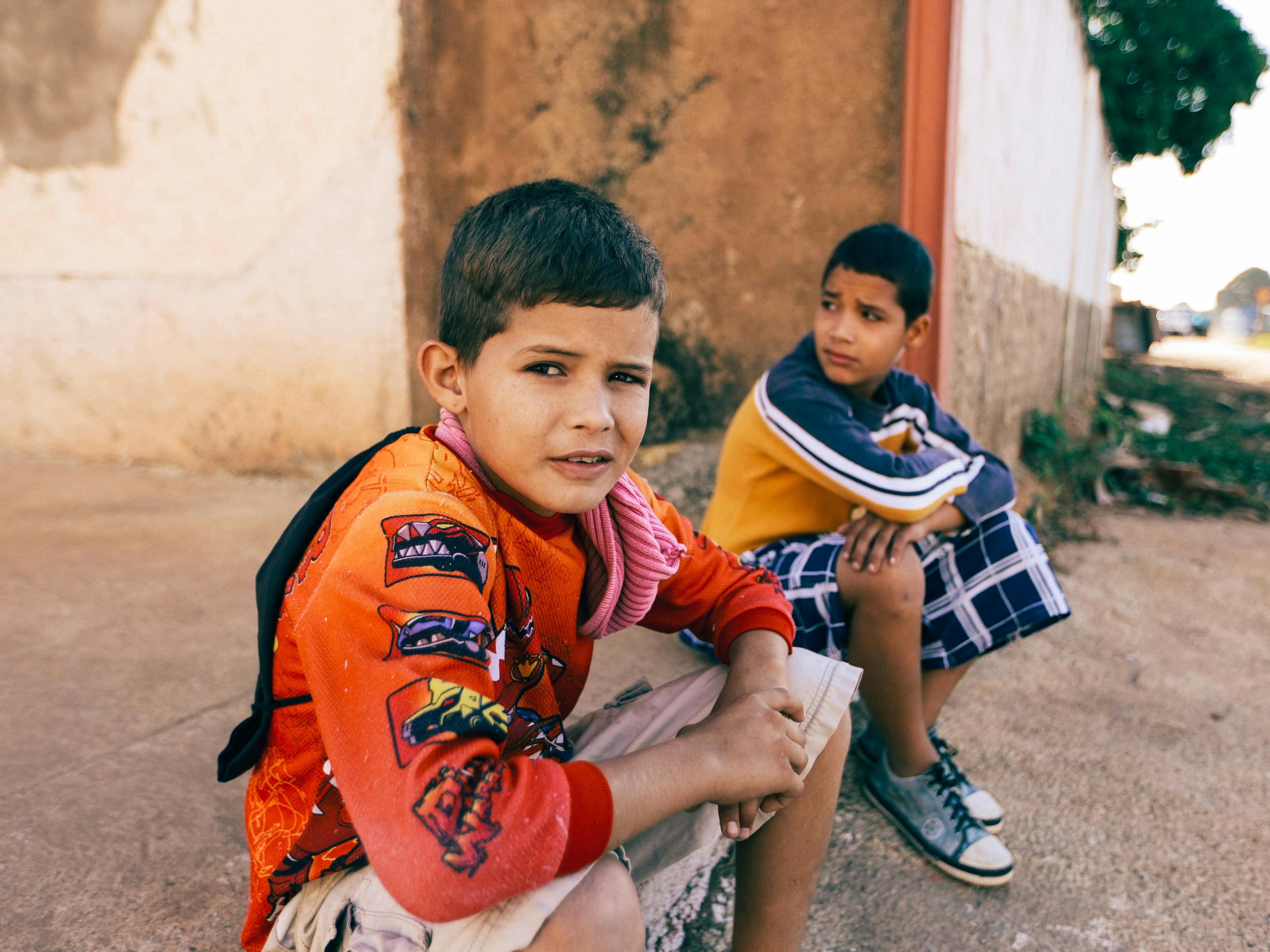 Portrait of Indian Boy Holding Water in Plastic Bottles · Free Stock Photo