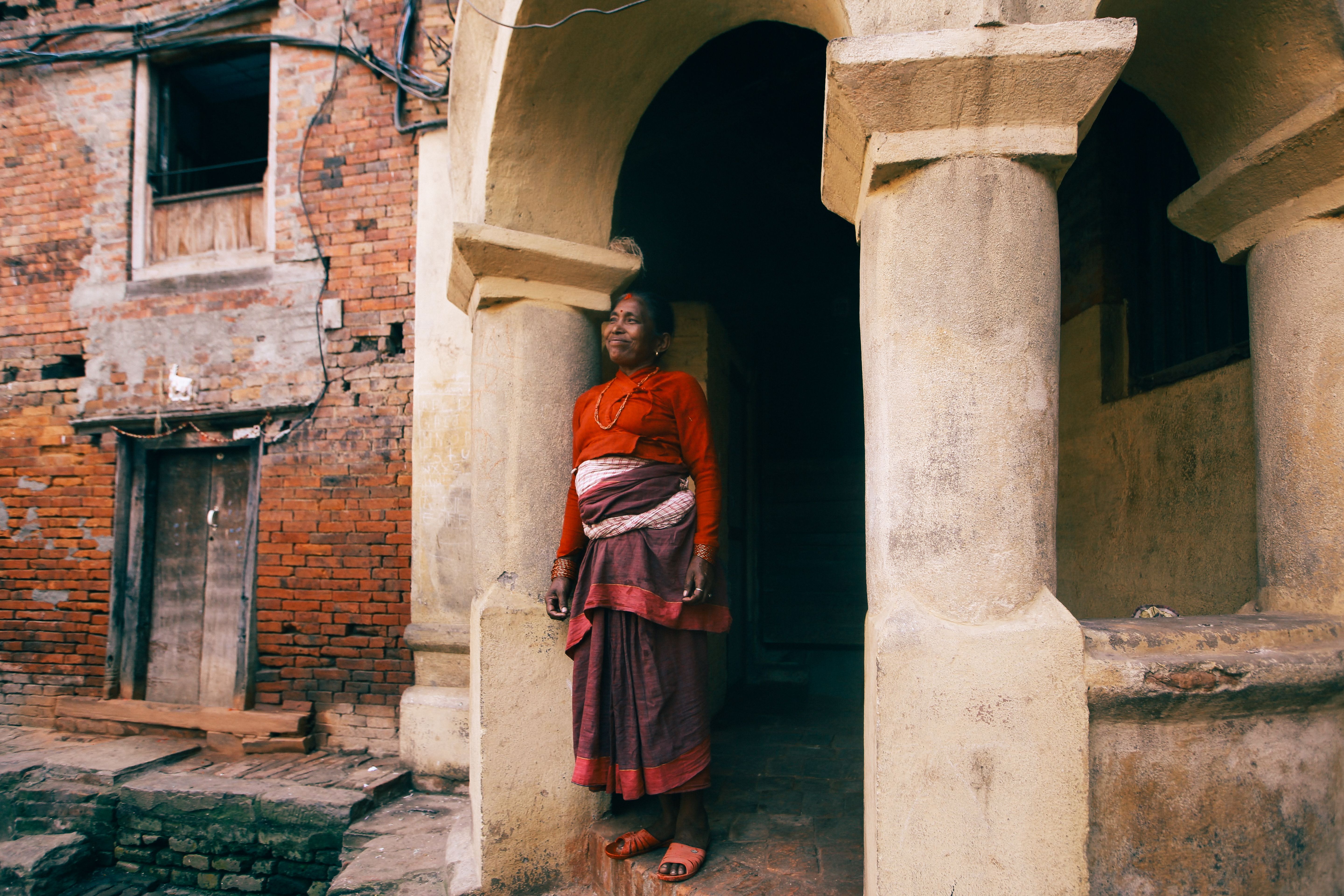 Woman Standing by Building Entrance · Free Stock Photo