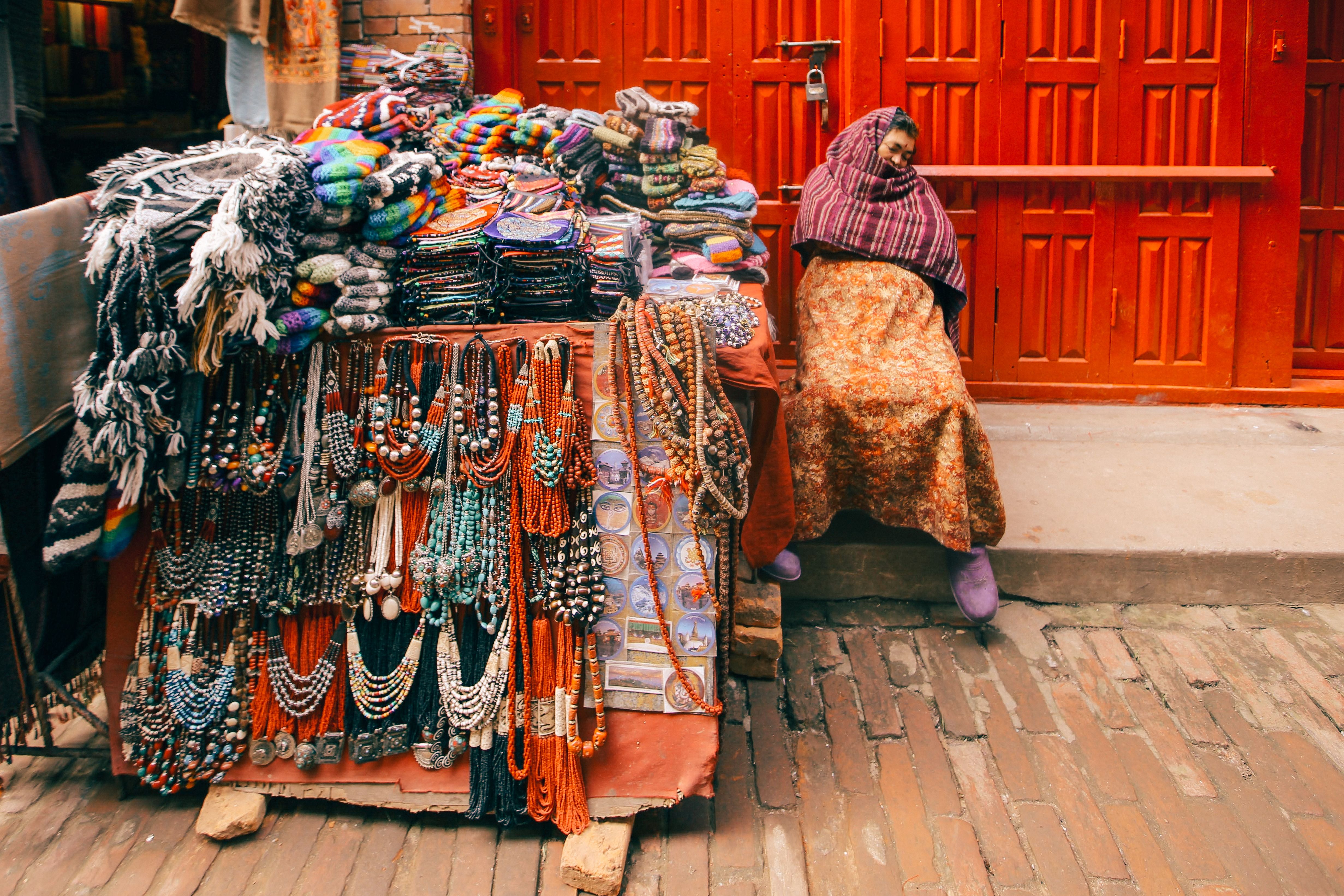 Woman Selling Clothing Items on the Sidewalk in a City · Free Stock Photo