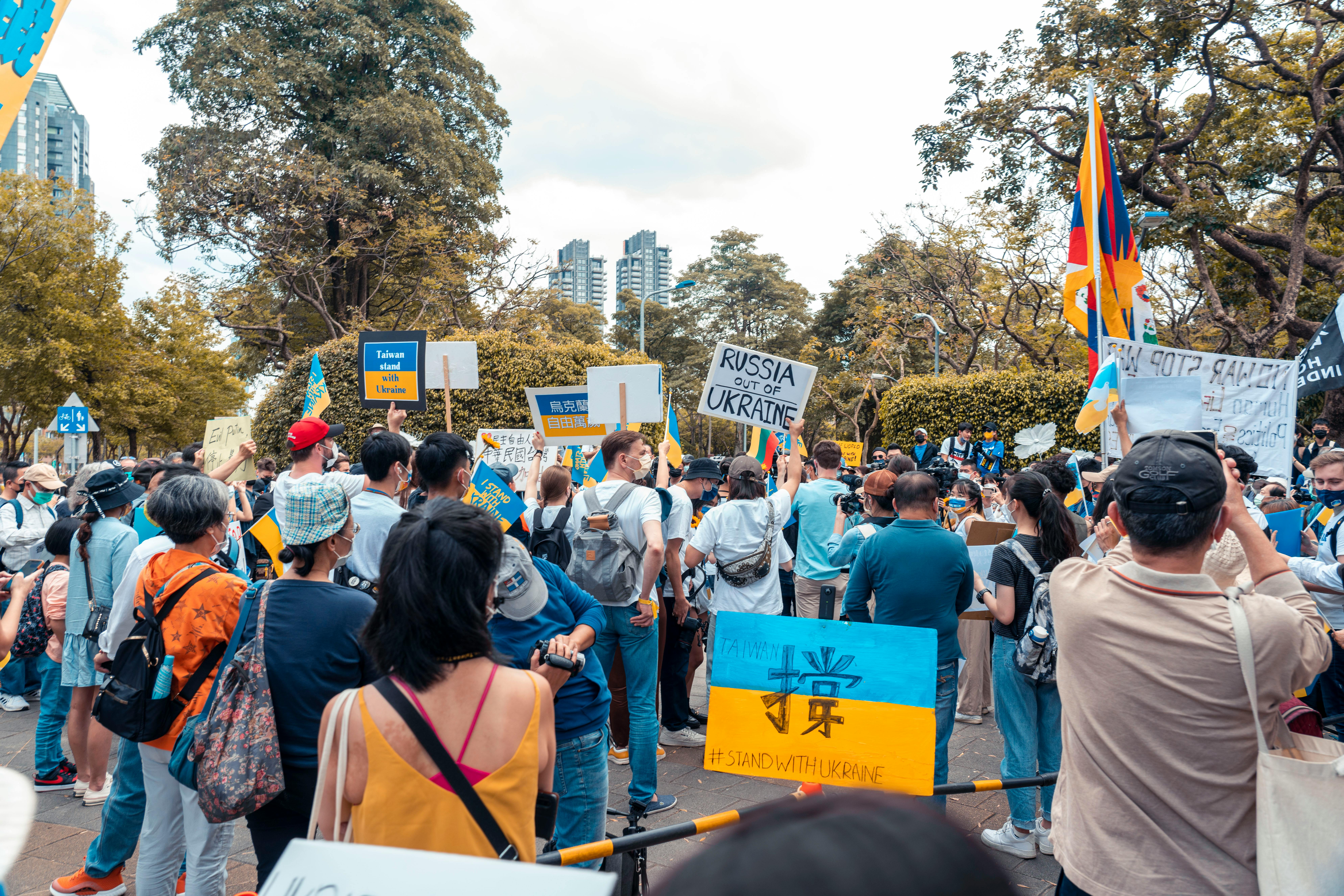 A Group of People Protesting on a Street Near Trees · Free Stock Photo