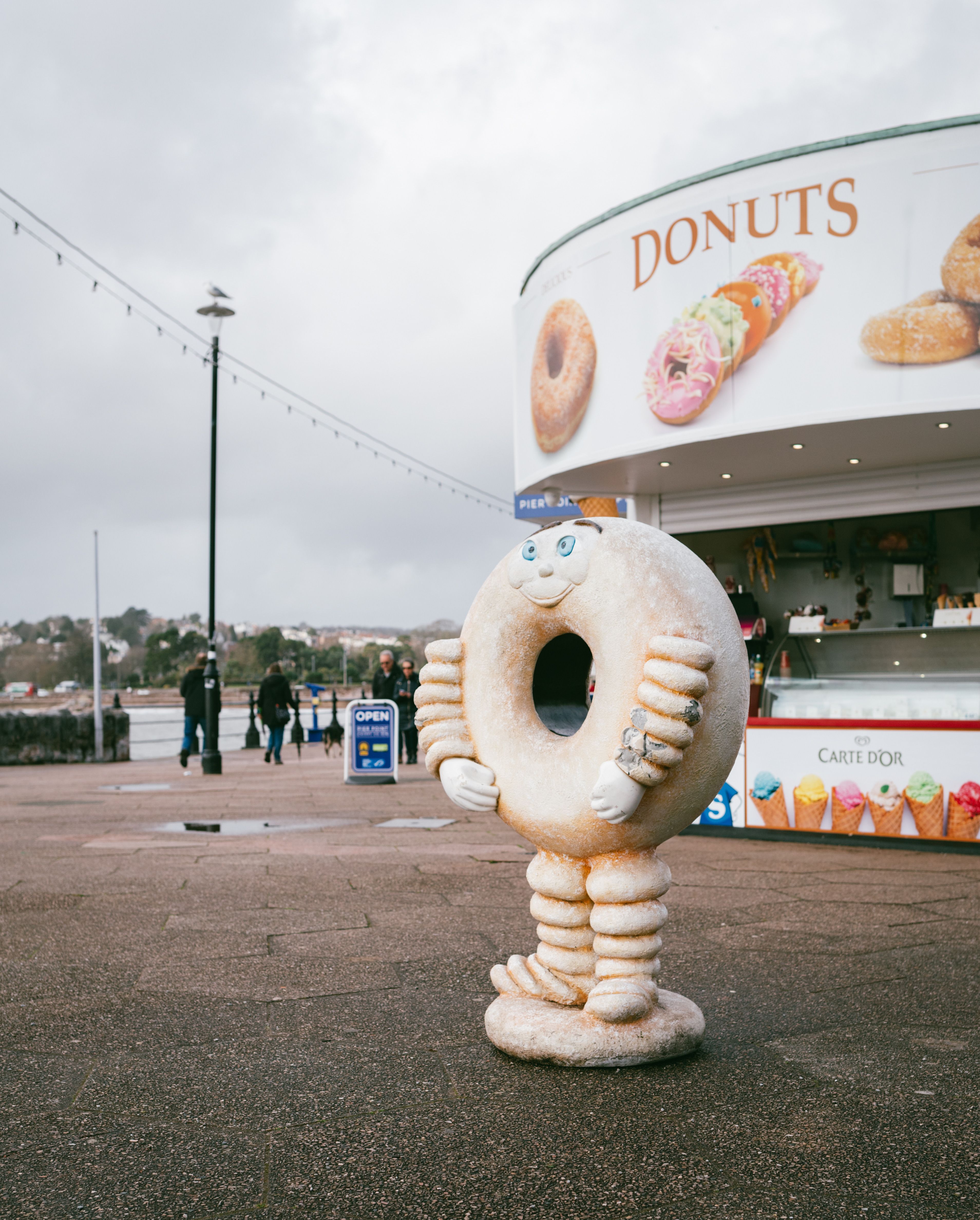 Figure in front of Donuts Store · Free Stock Photo