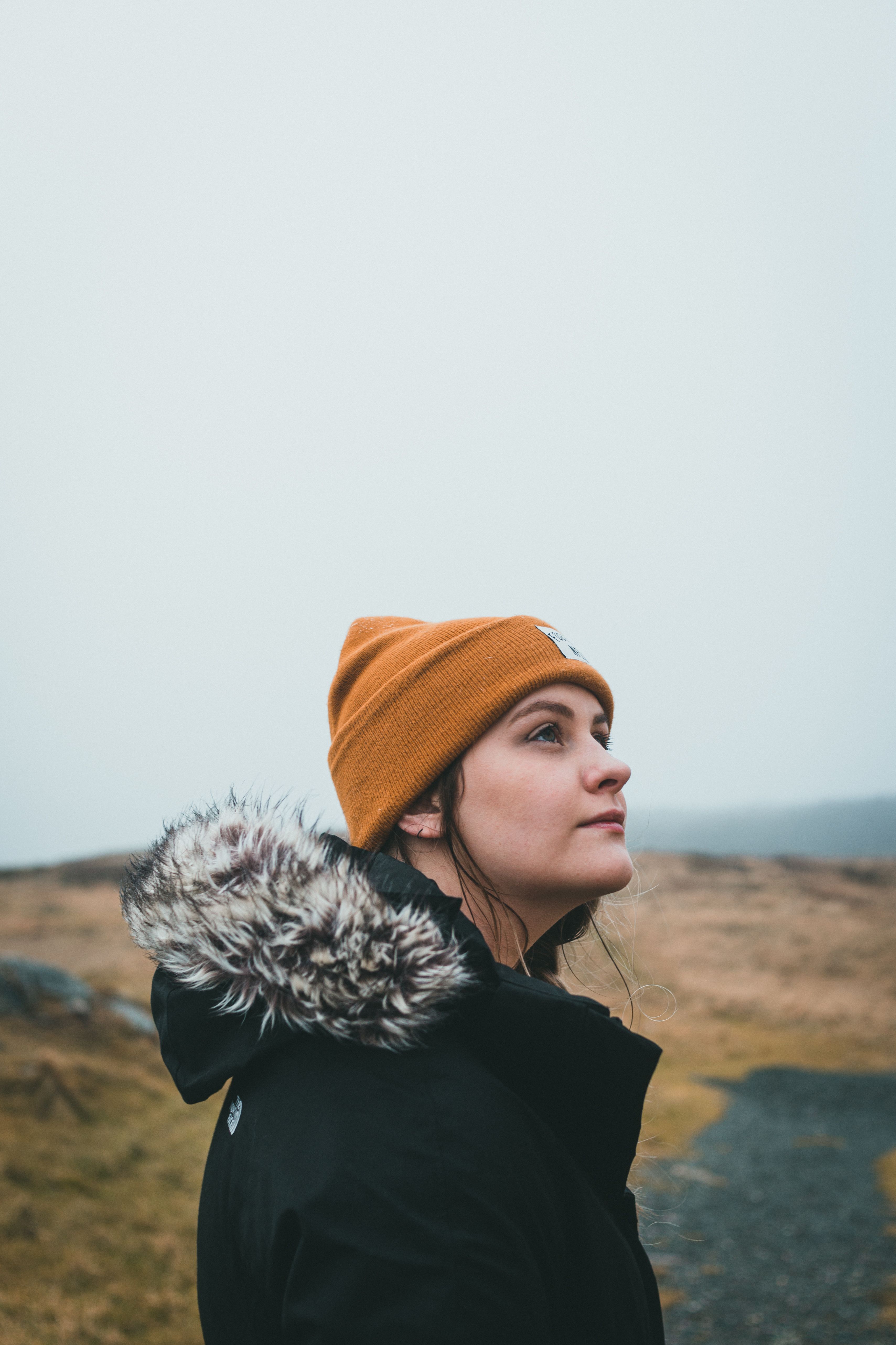 Woman Wearing a Beanie and Jacket Looking Up · Free Stock Photo