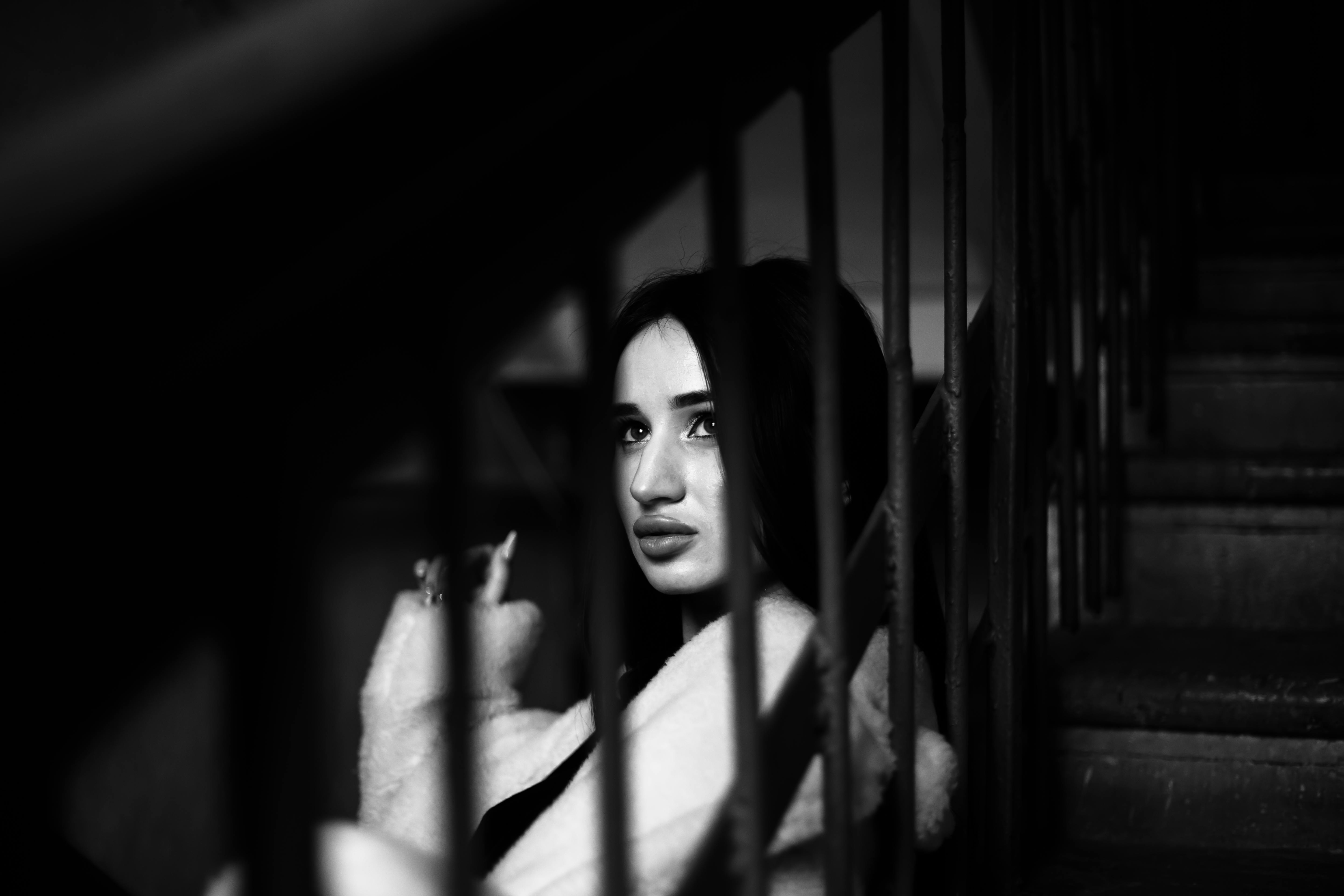 Woman Posing behind Bars in Black and White · Free Stock Photo