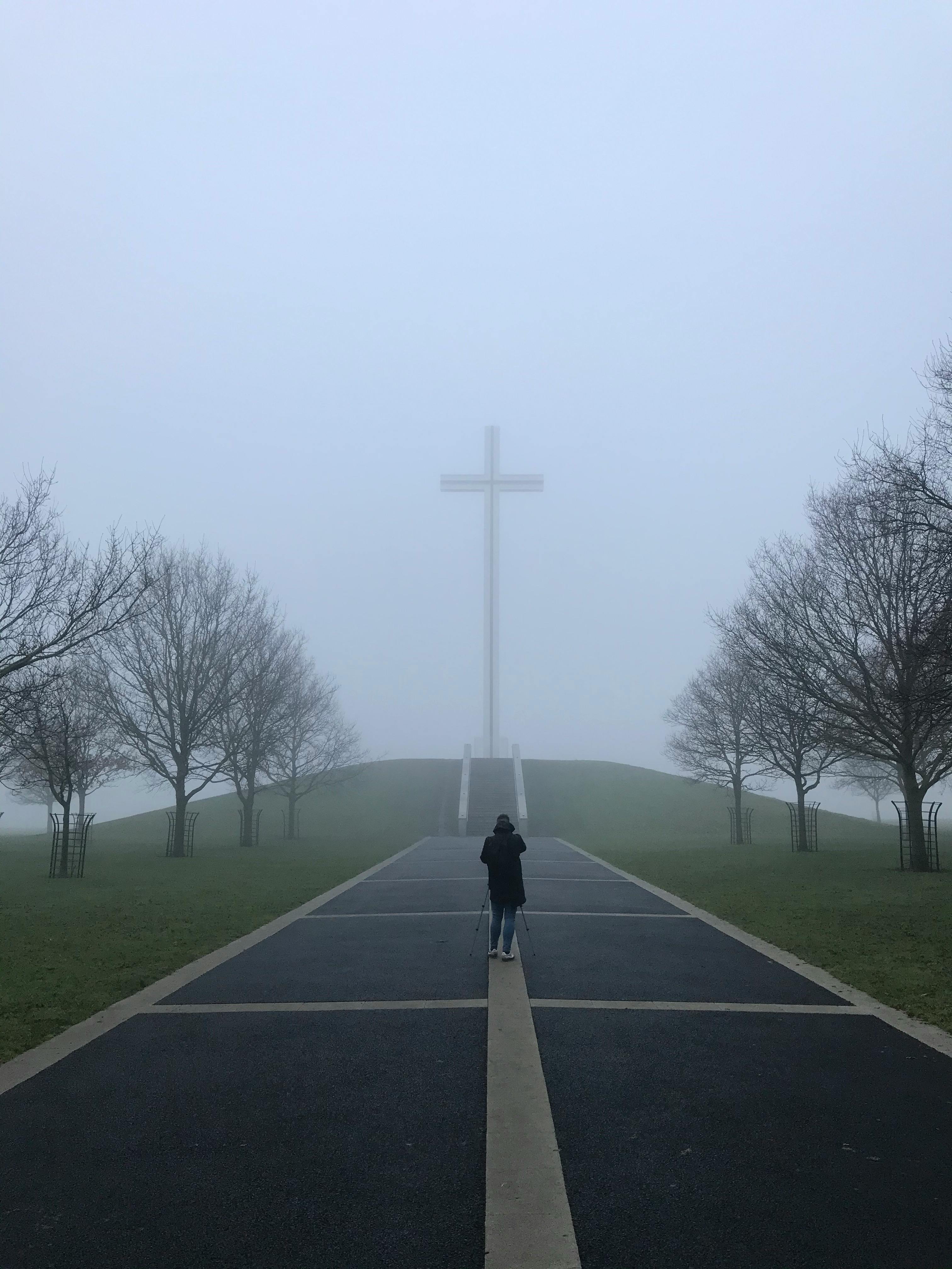 A Person Standing in Front of the Cross · Free Stock Photo
