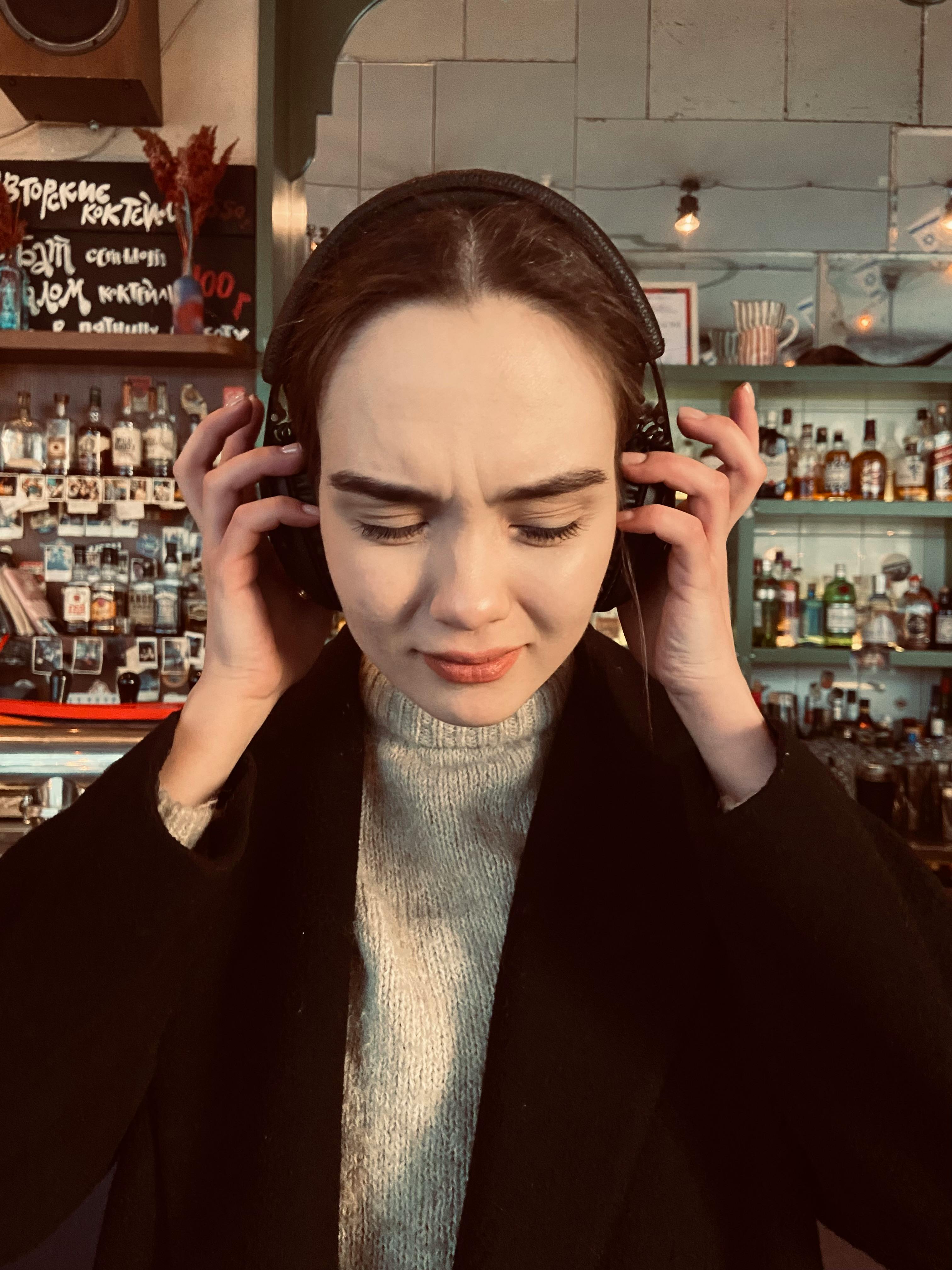 Portrait of Woman in Cafe Putting on Headphones · Free Stock Photo