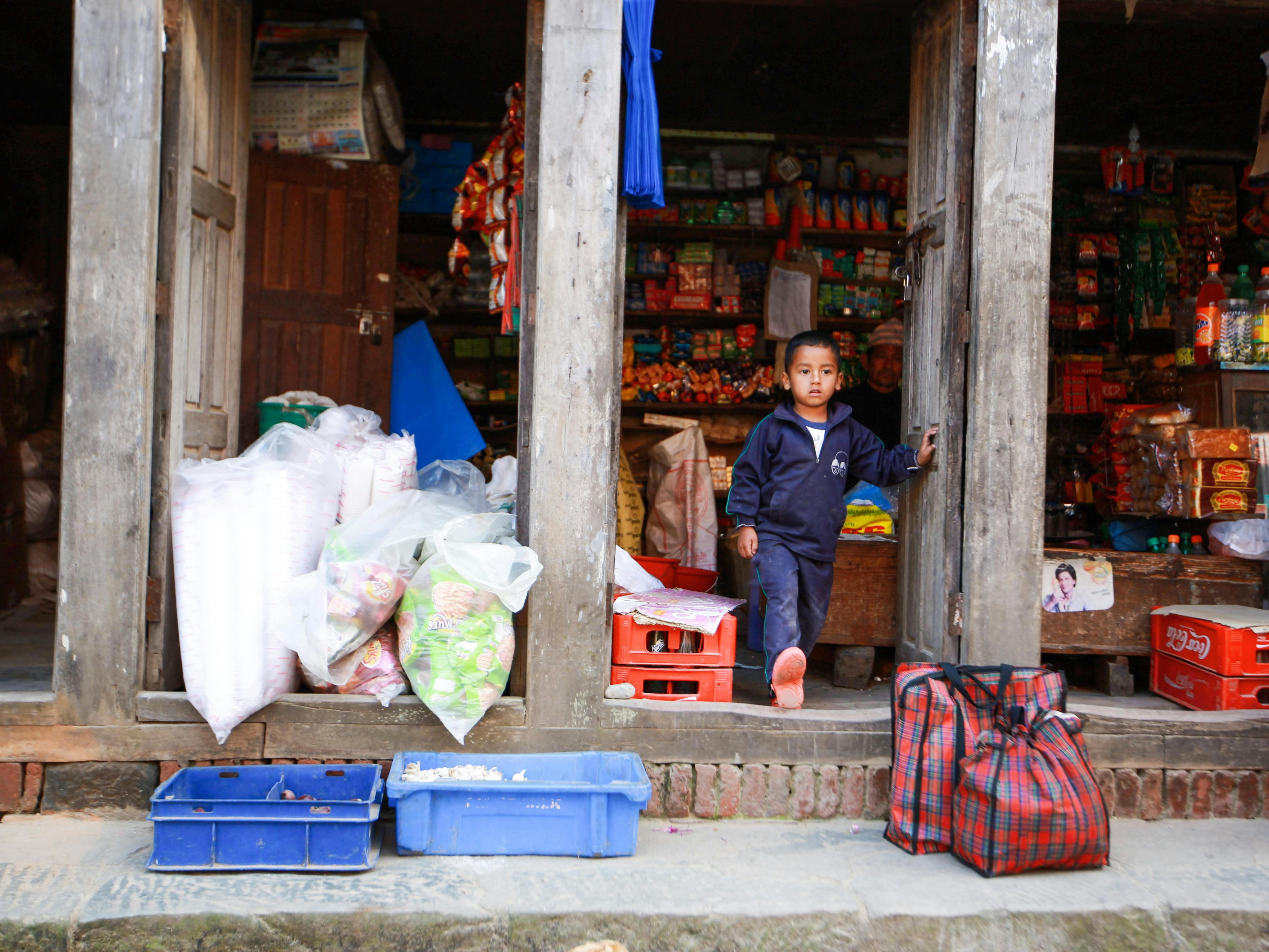 A Boy Walking Out of a Store · Free Stock Photo
