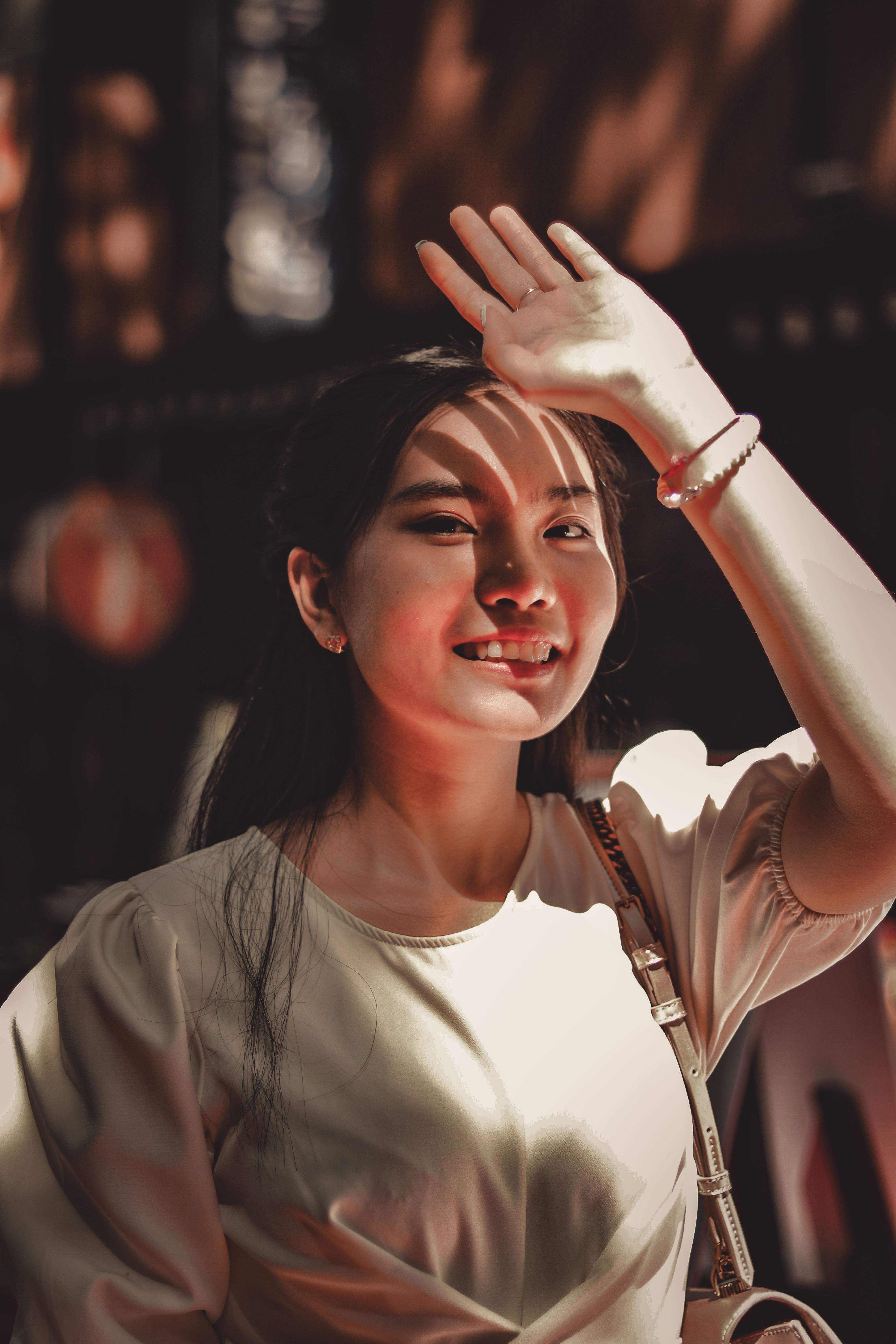 A Woman Raising Arm while Smiling at the Camera · Free Stock Photo