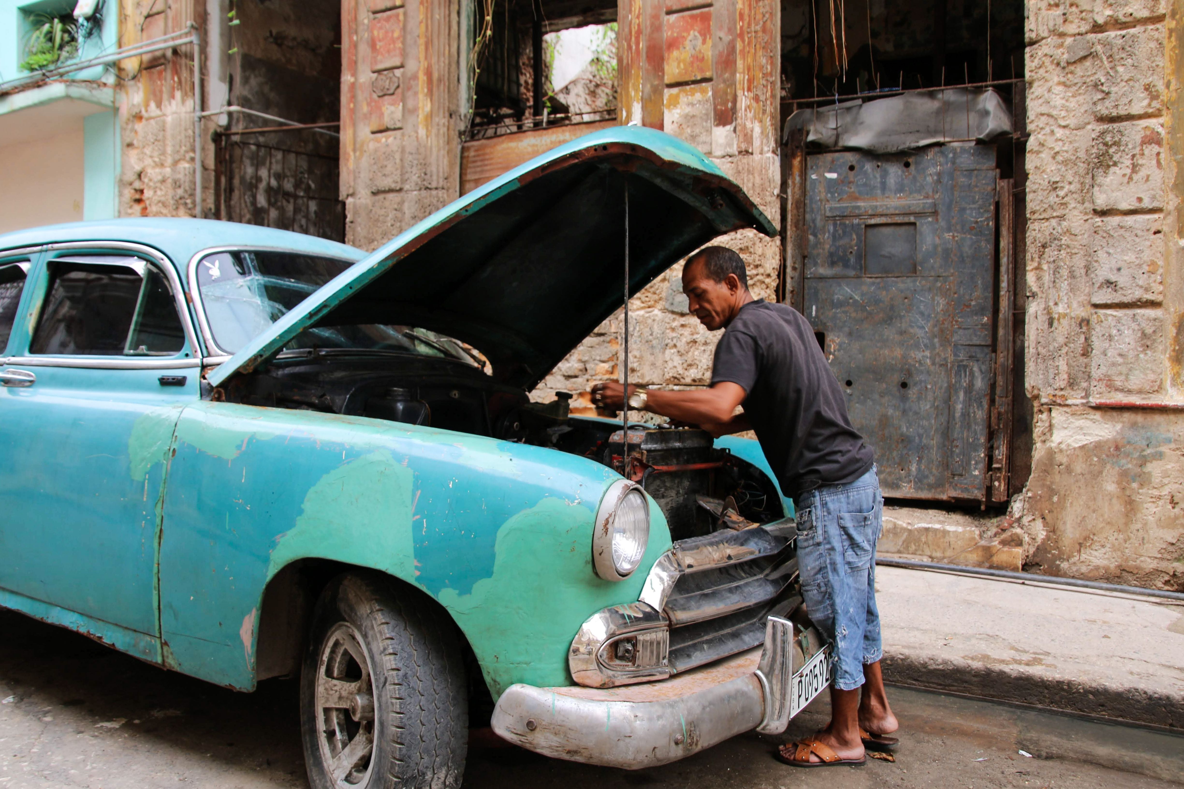 Man Repairing Blue Car on Roadside · Free Stock Photo
