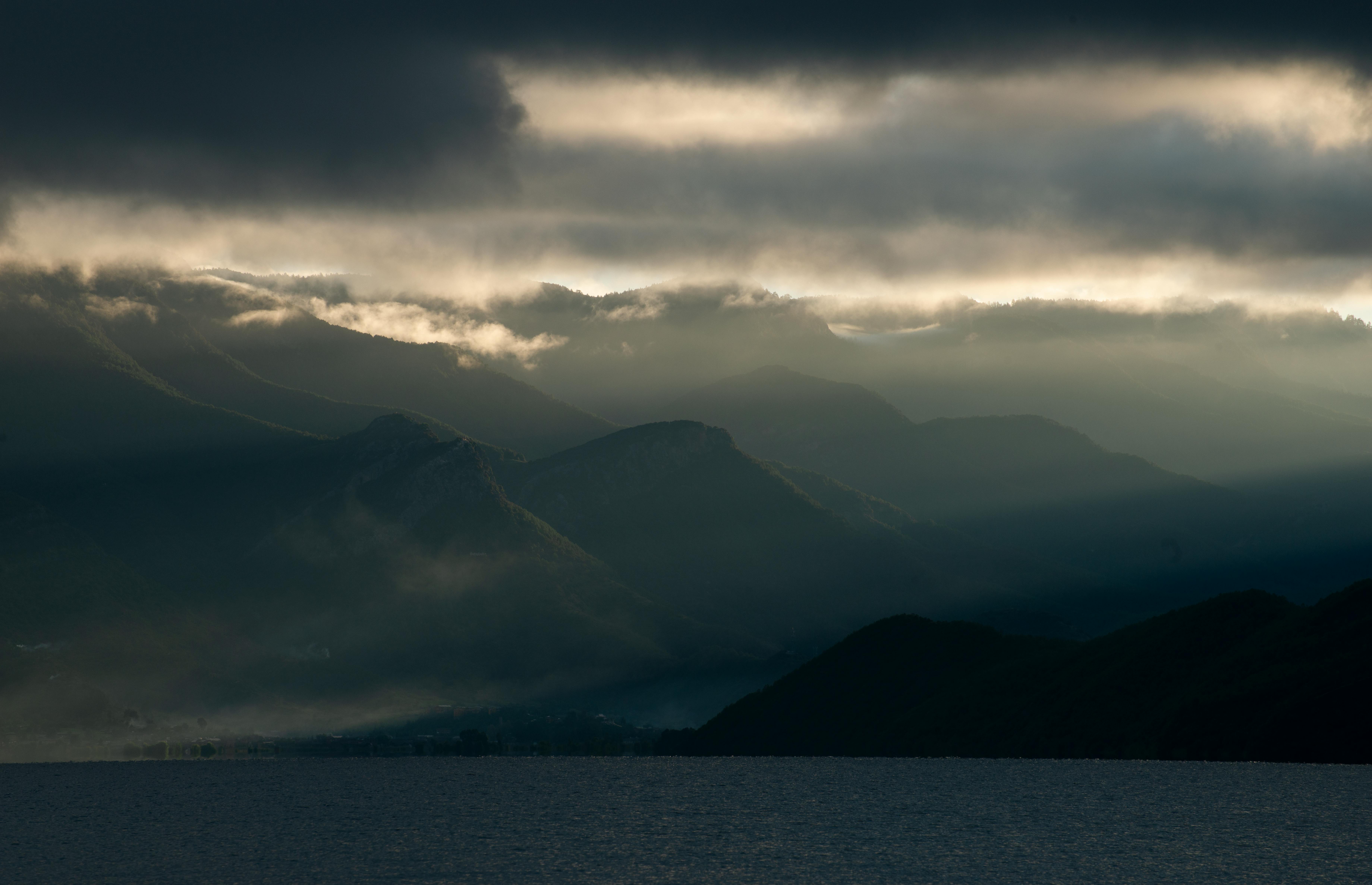 Clodus over Mountains on Sea Shore · Free Stock Photo