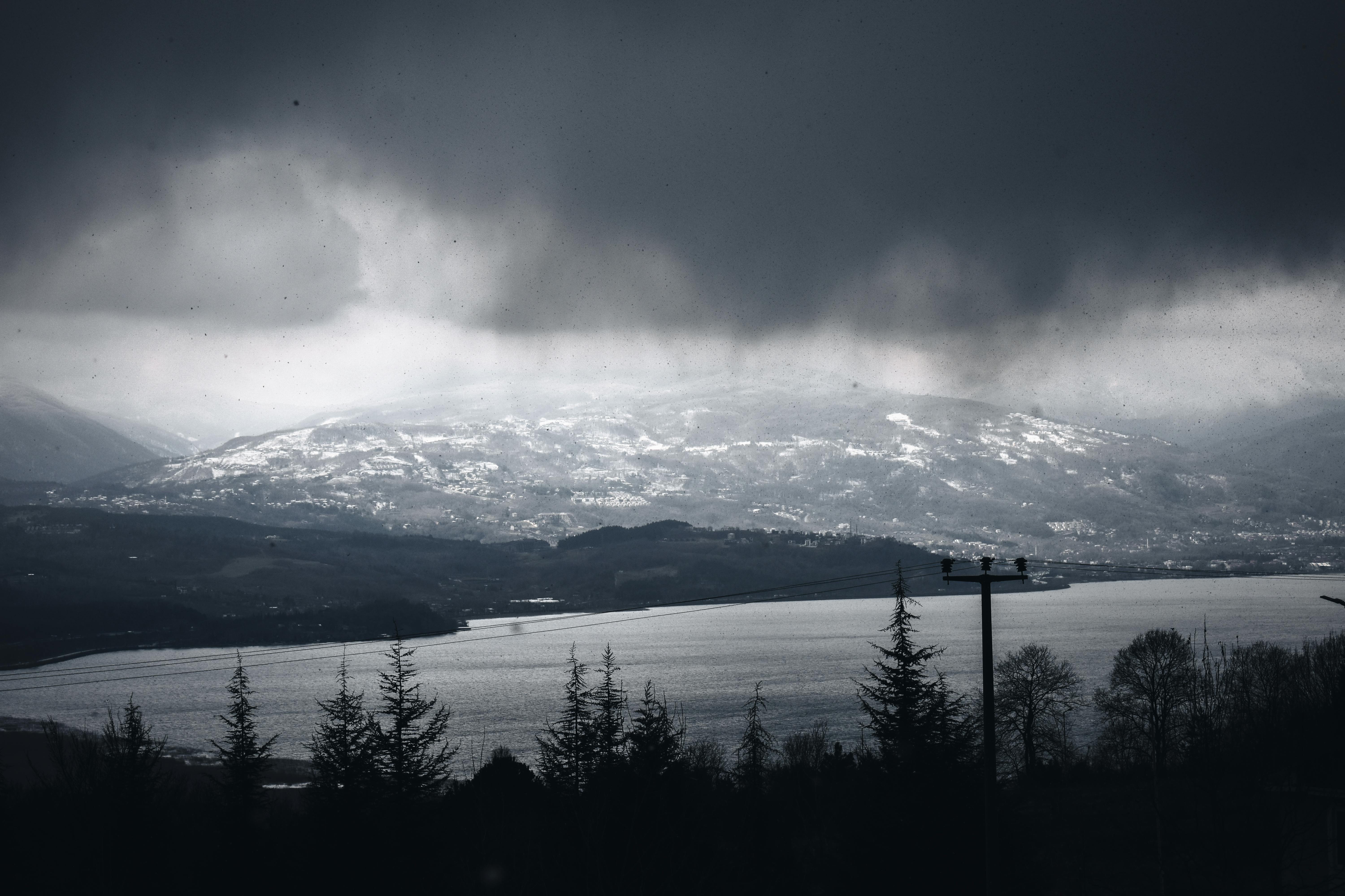 Dark Clouds Over Lake and Mountains · Free Stock Photo