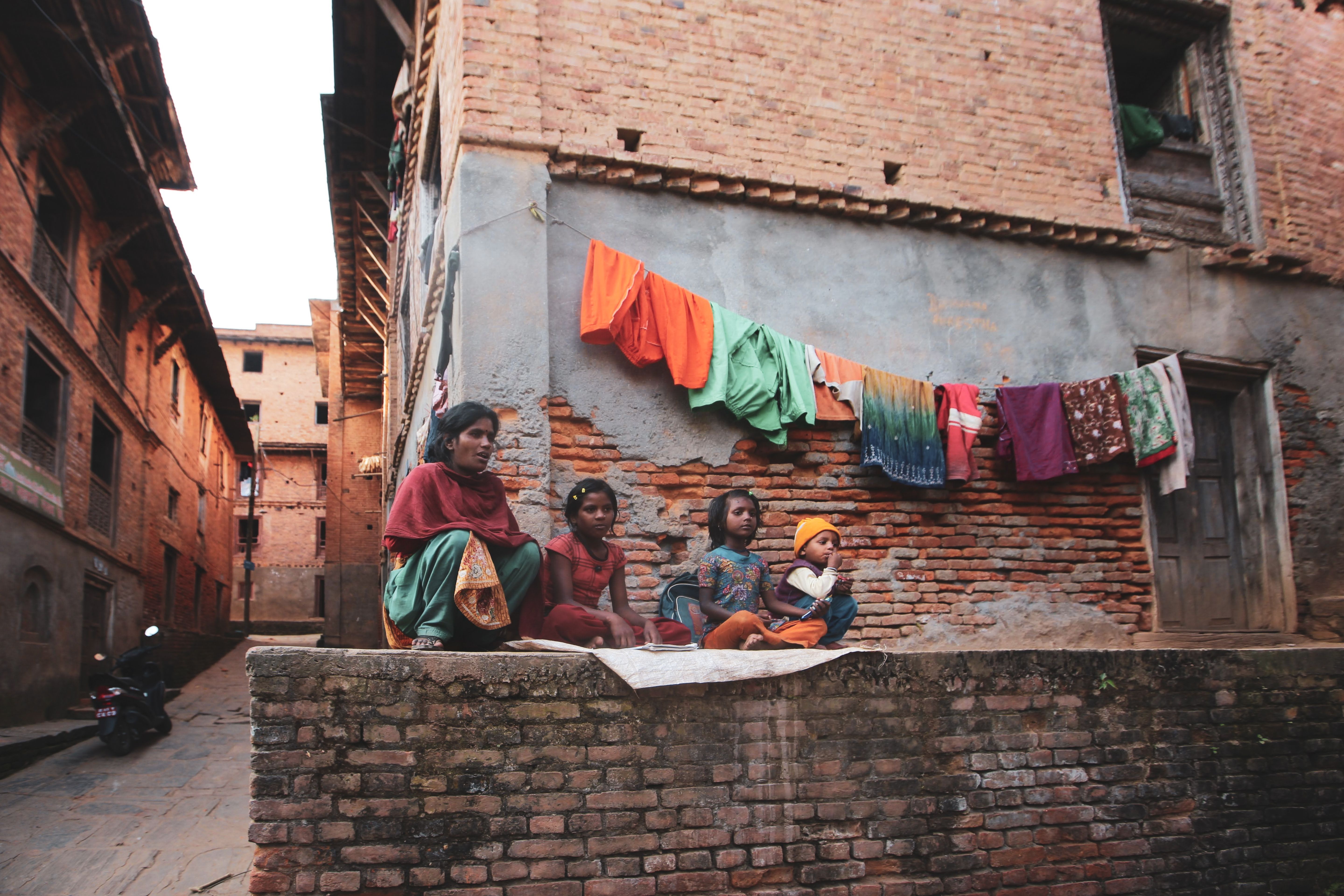 People Sitting on Brown Brick Wall · Free Stock Photo