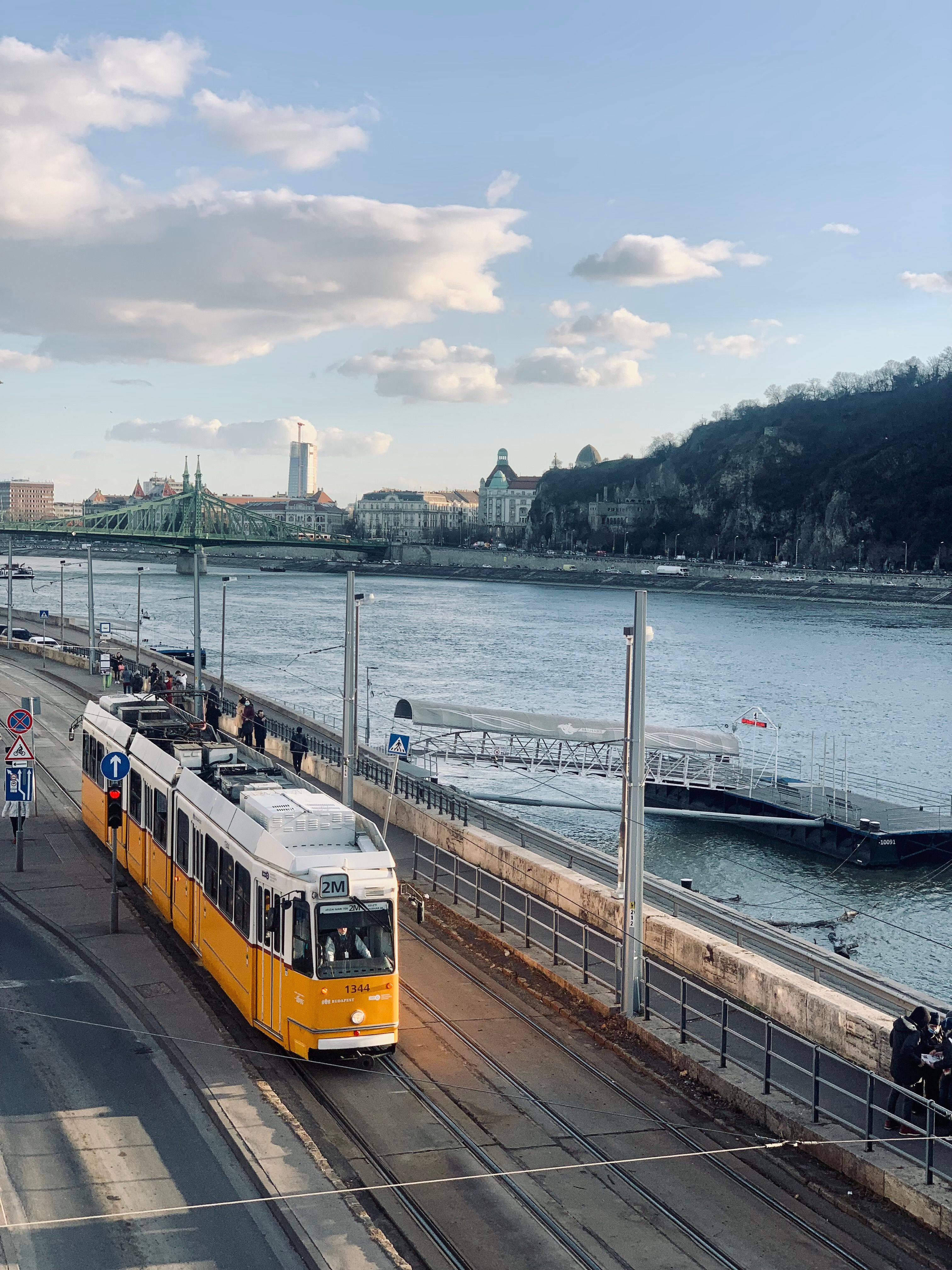 Yellow and White Tram on Tramline Near a Body of Water · Free Stock Photo
