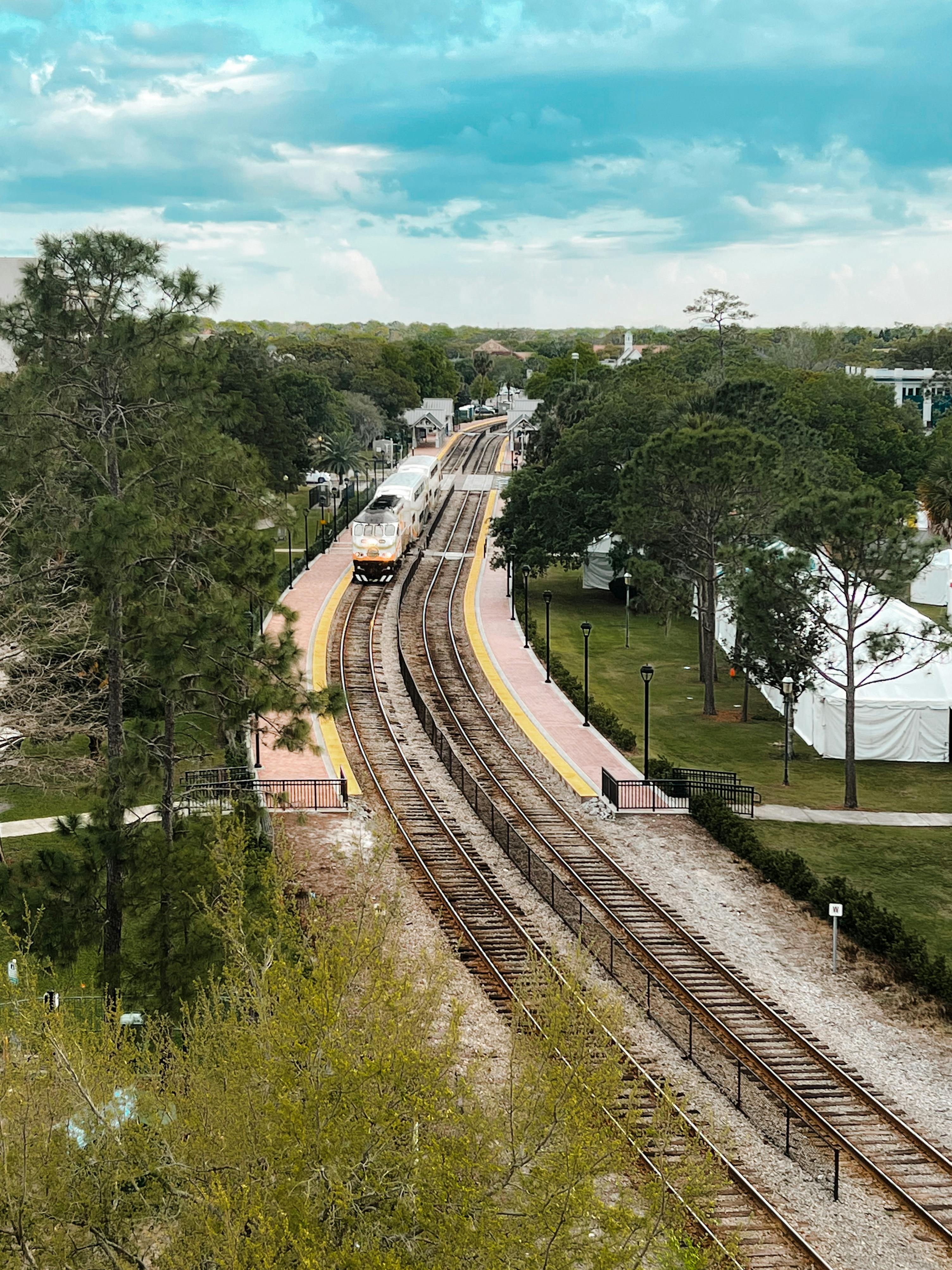 Train Rail Road Between Green Trees Under Blue Sky · Free Stock Photo