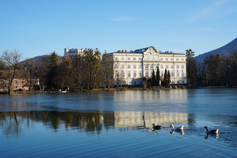 Beautiful reflection of Leopoldskron Palace on a serene lake in Austria.