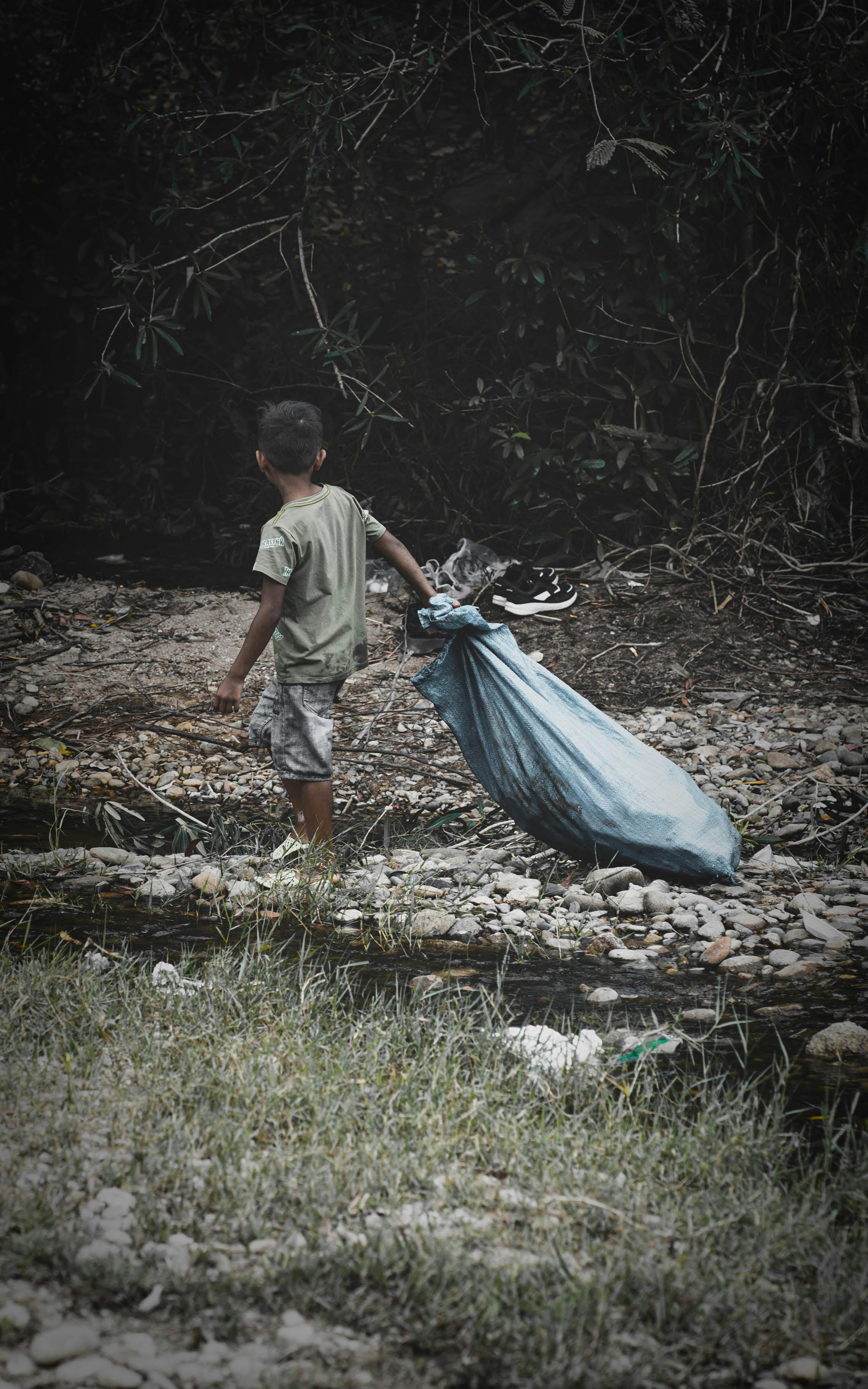 A Boy Holding Blue Sack · Free Stock Photo