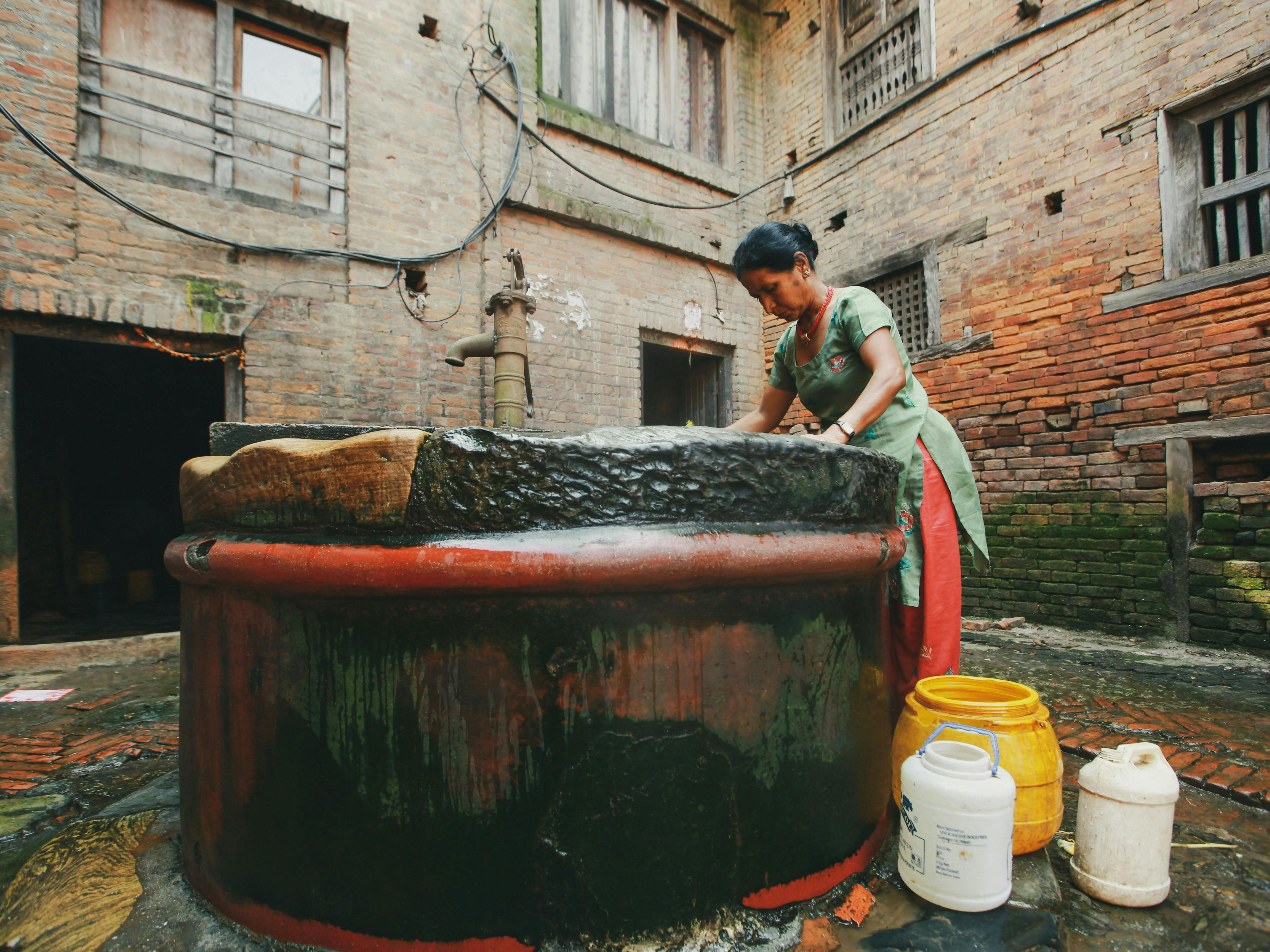 Woman Pulling Water out of Well · Free Stock Photo