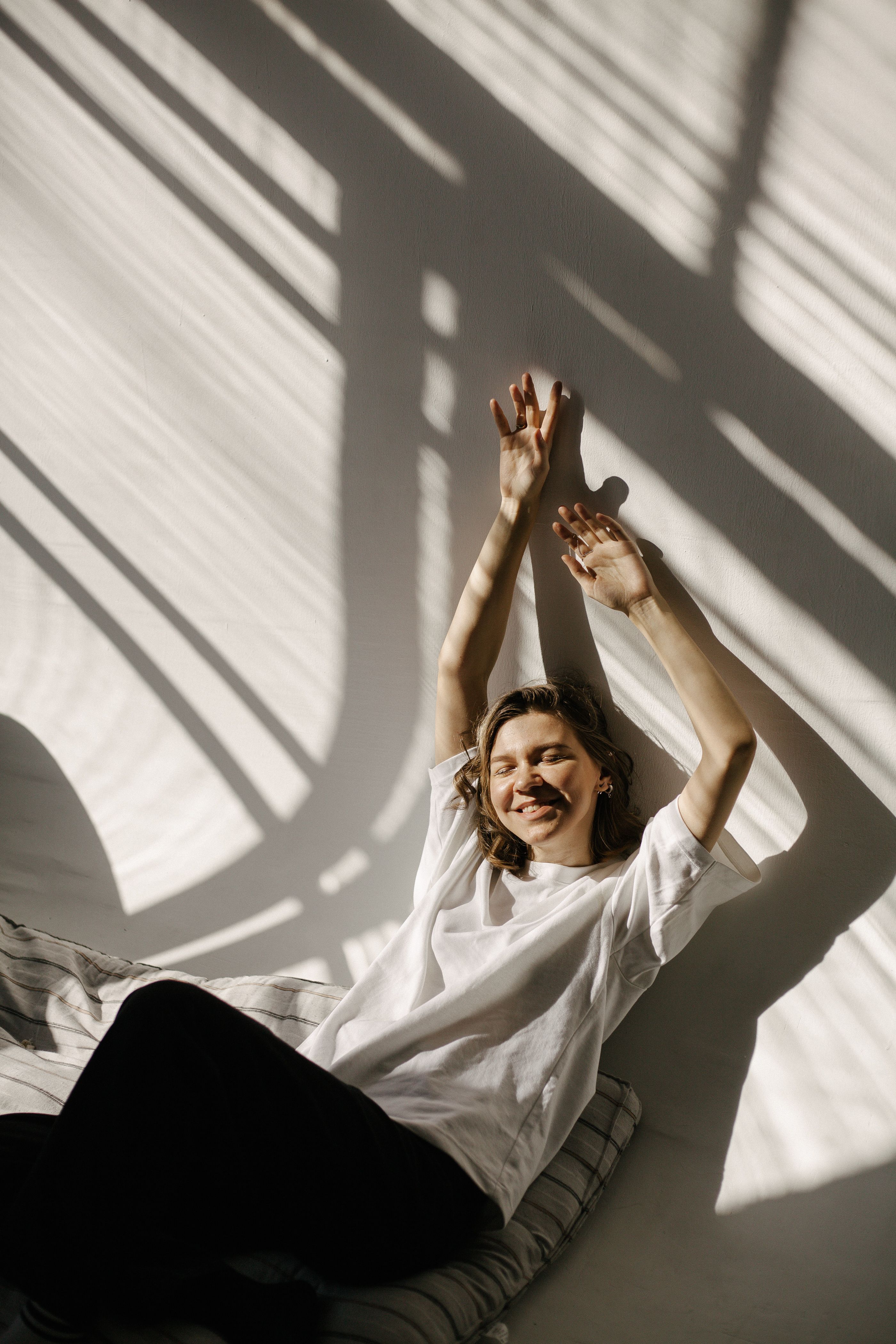 Woman Lying Leaning Against the Wall with Arm Up · Free Stock Photo