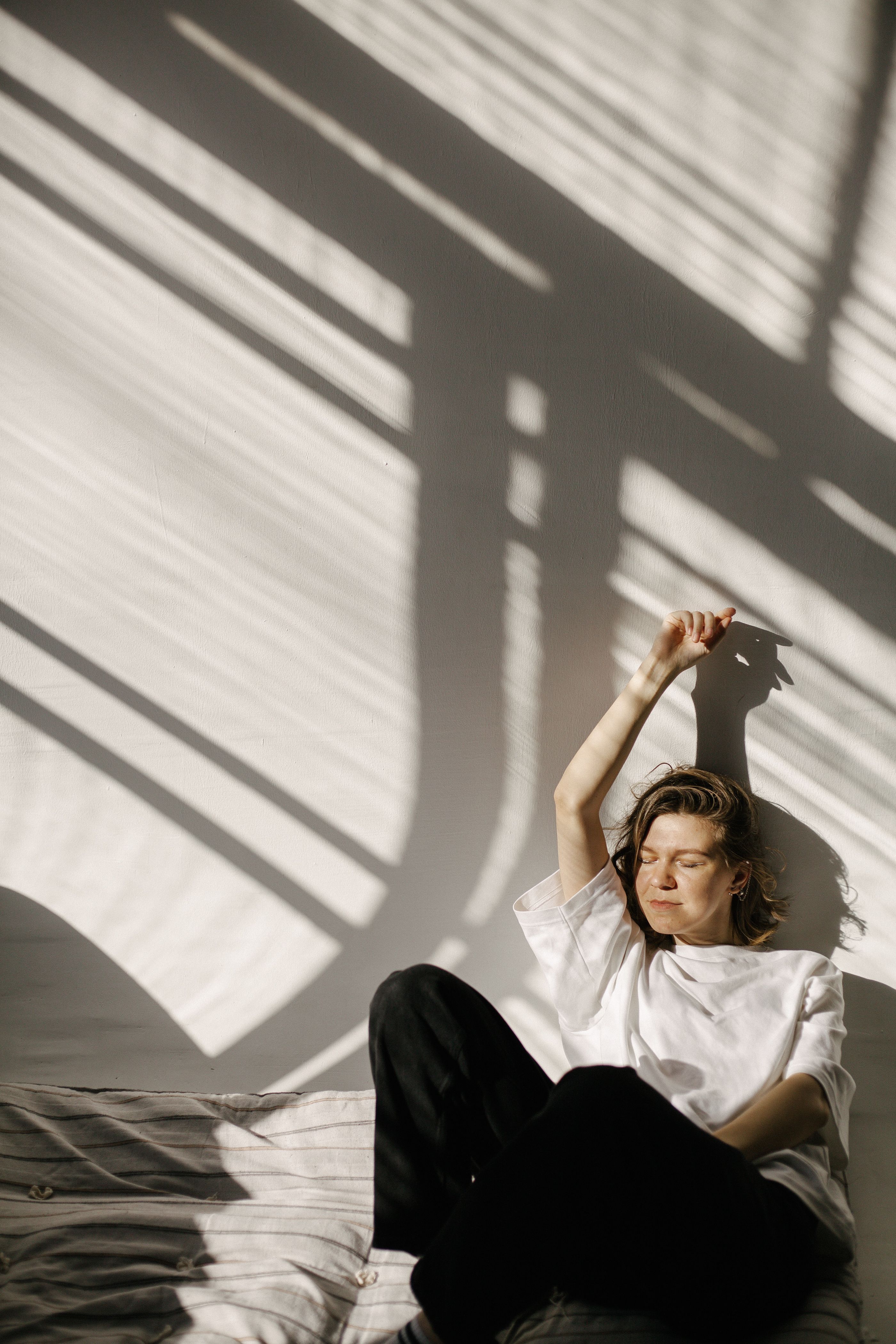 Woman Lying Leaning Against the Wall with Arm Up · Free Stock Photo