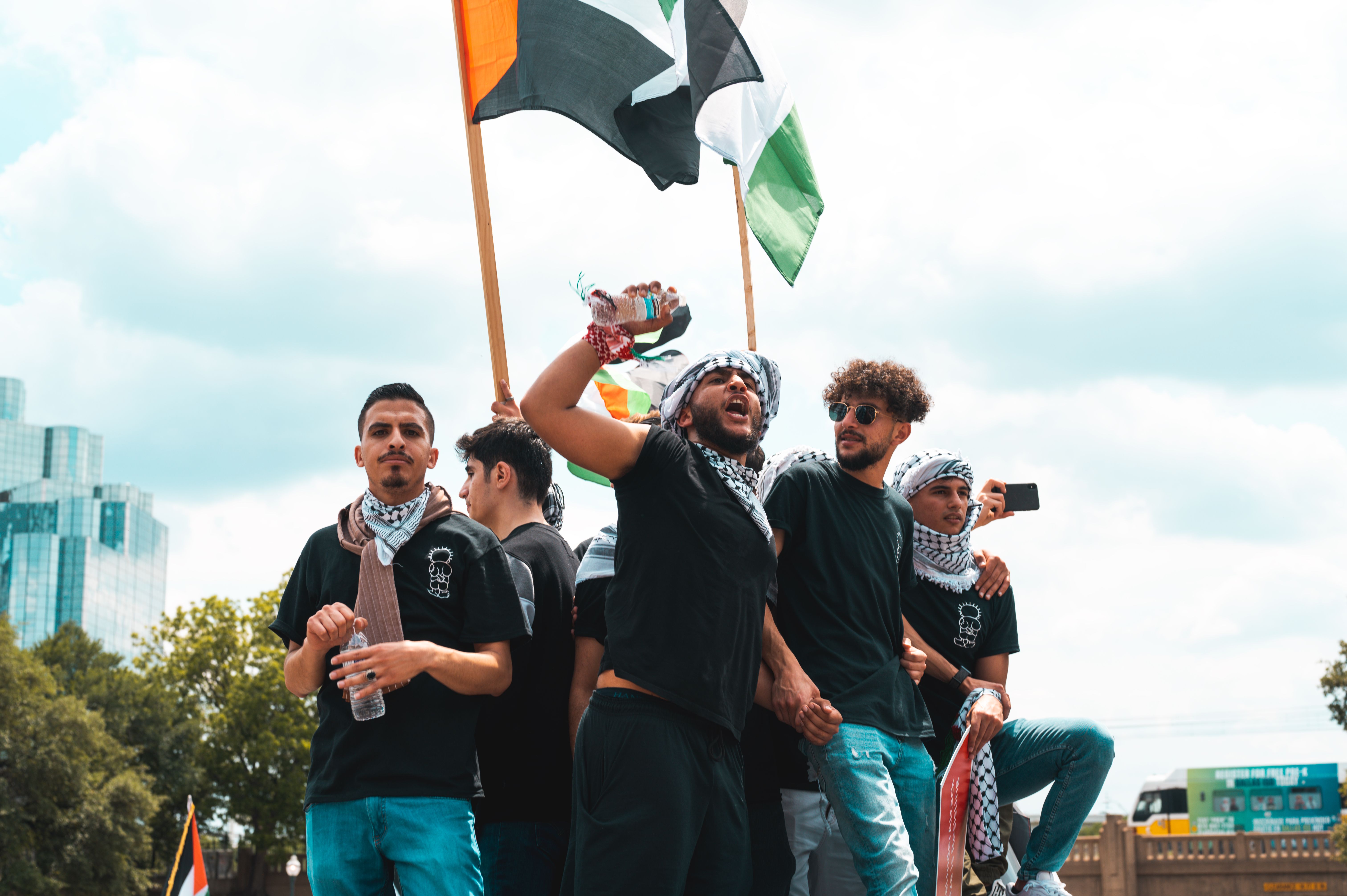A Group of Men with Black and White Turbans Holding Flags During a ...