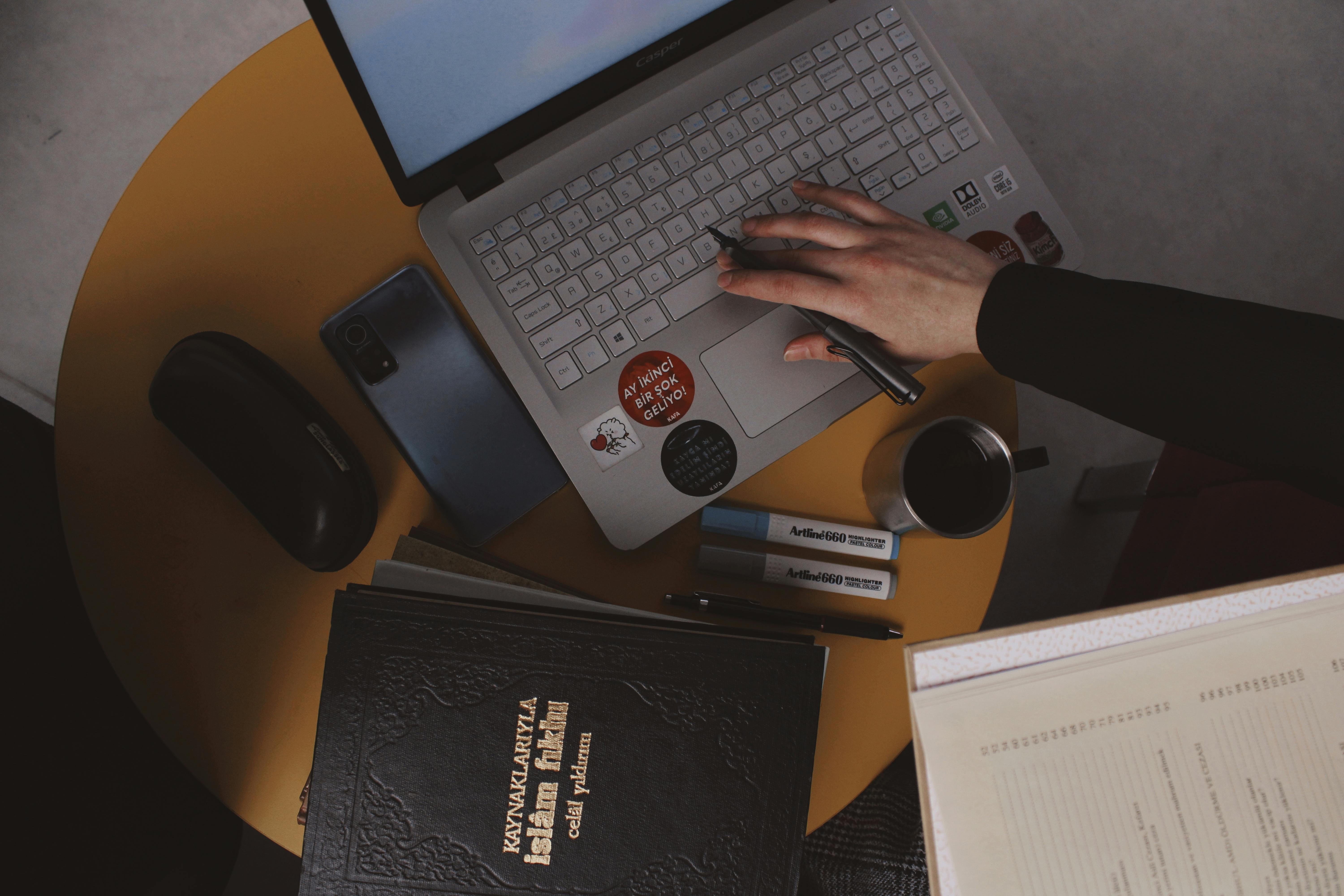 Person Using Macbook Pro on Brown Wooden Table · Free Stock Photo
