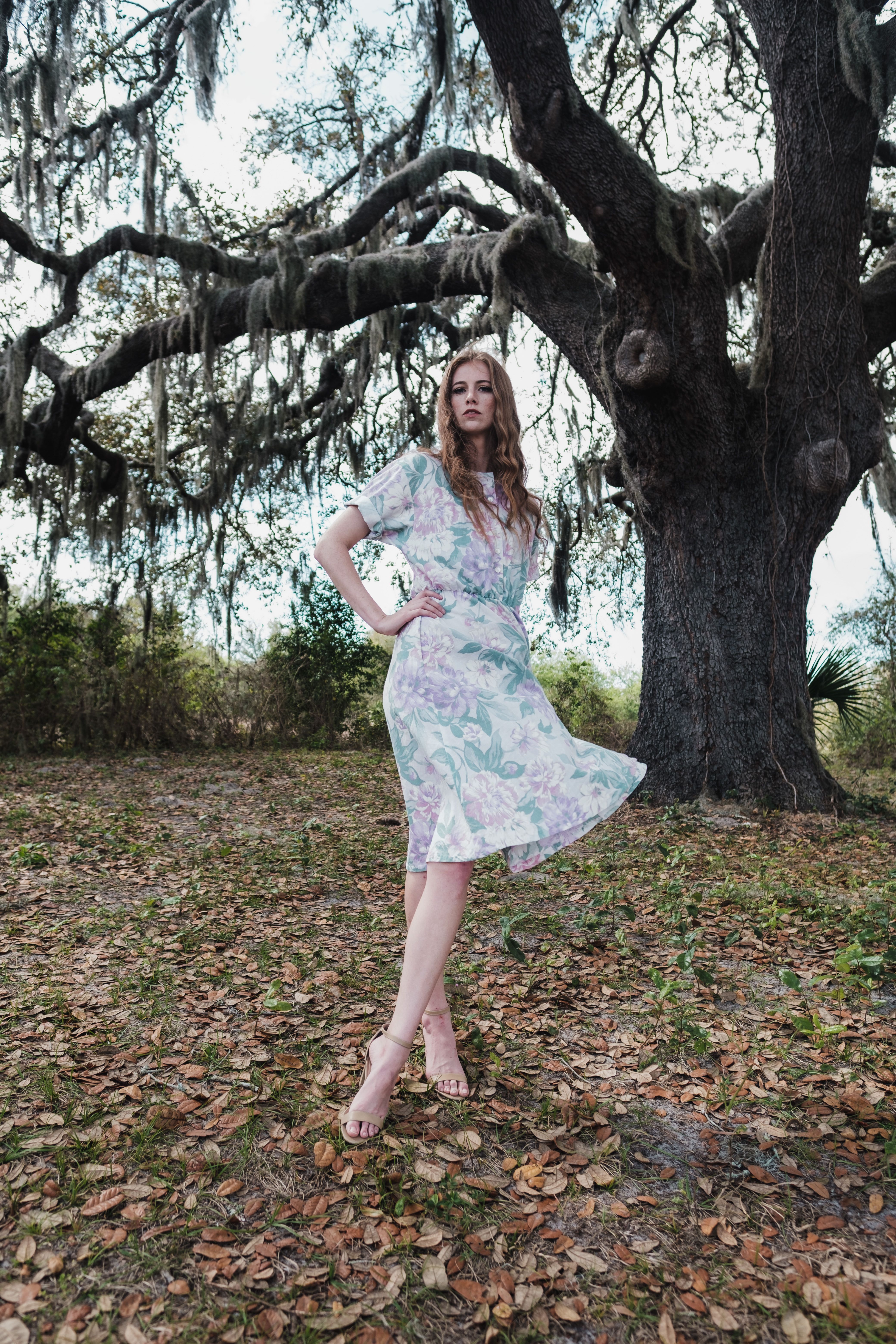 Stylish Woman in Floral Dress standing in front of a Tree · Free Stock ...