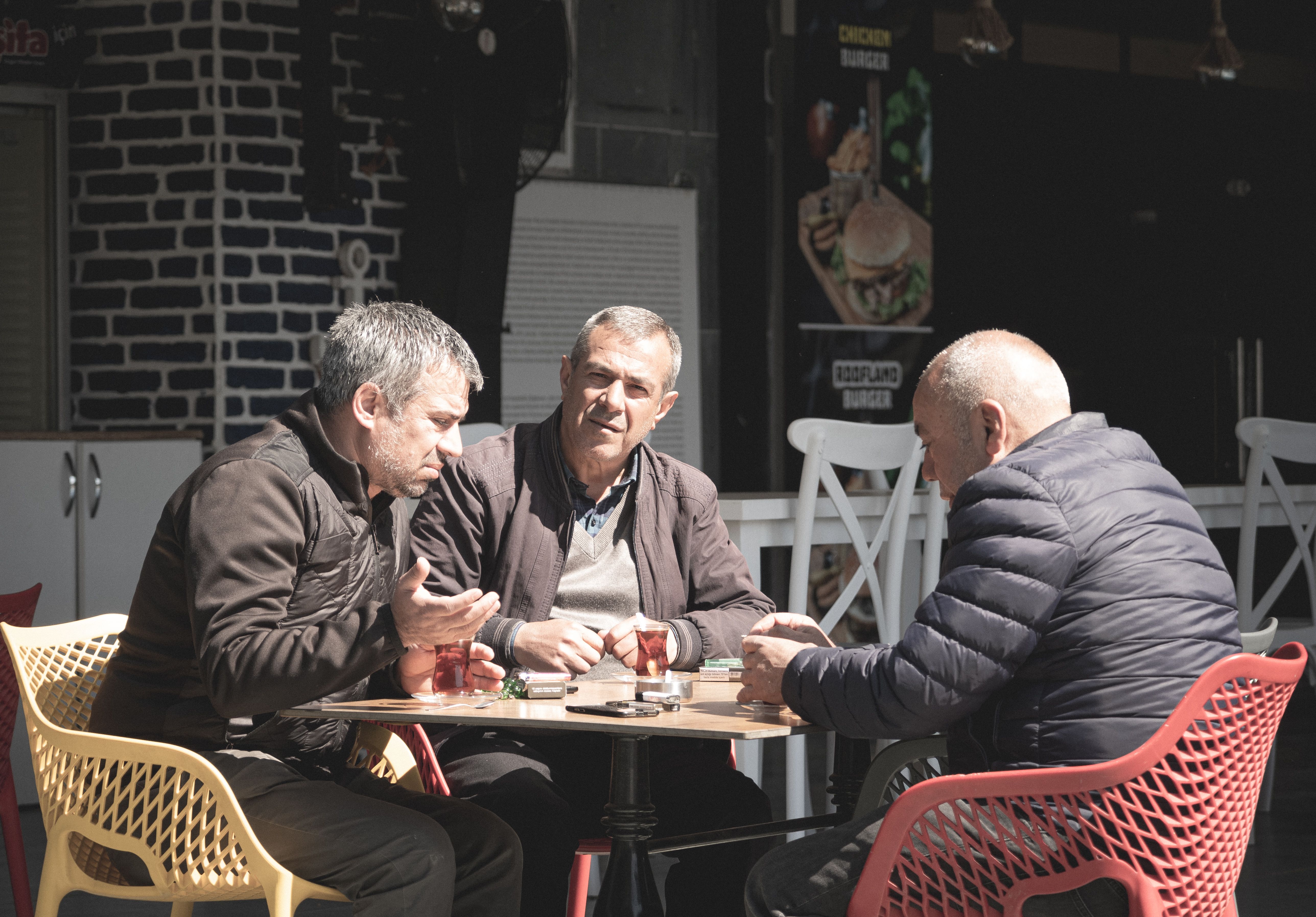 Three Men Sitting in a Restaurant Patio · Free Stock Photo