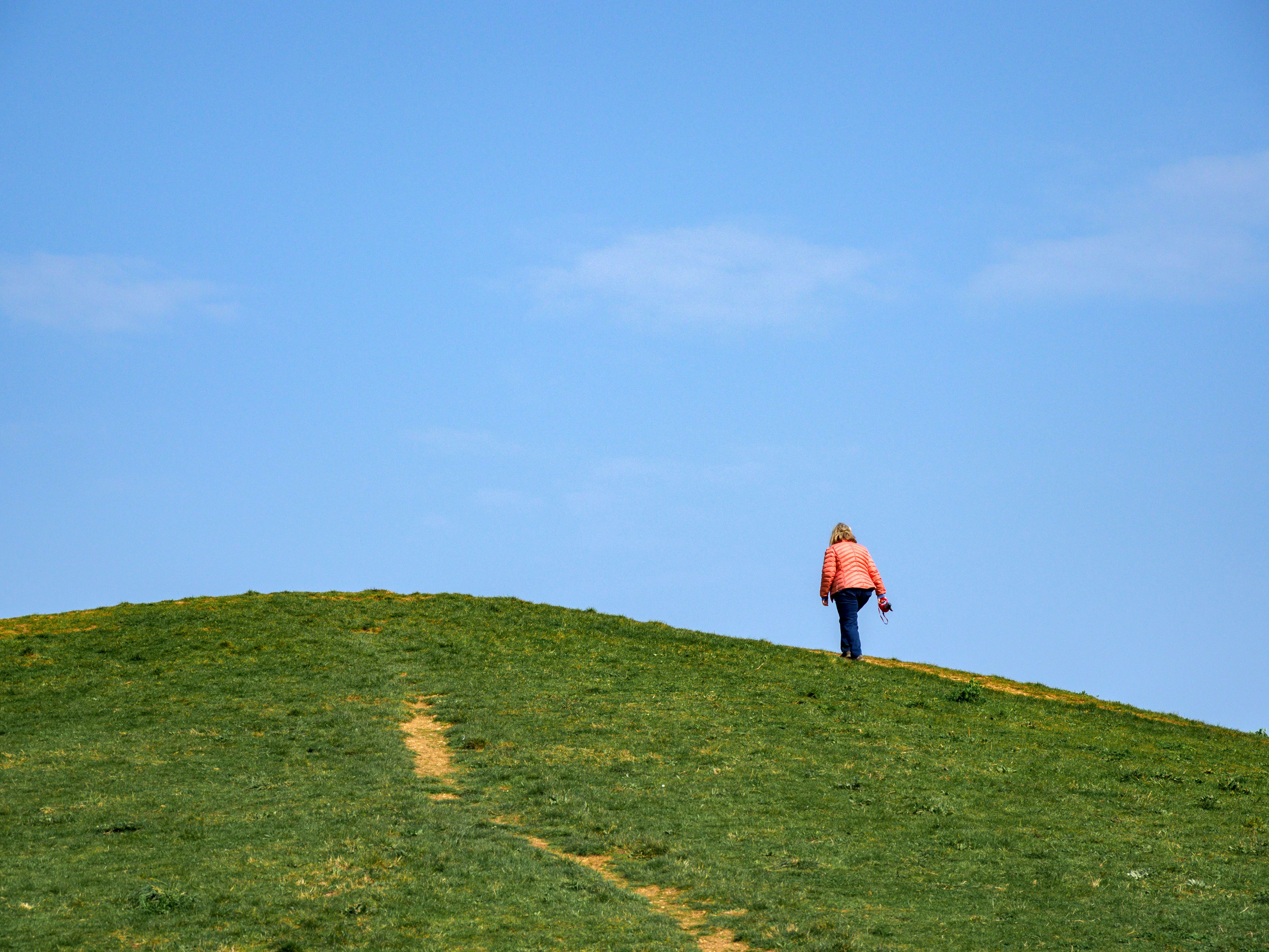 Woman Walking Up a Hill · Free Stock Photo