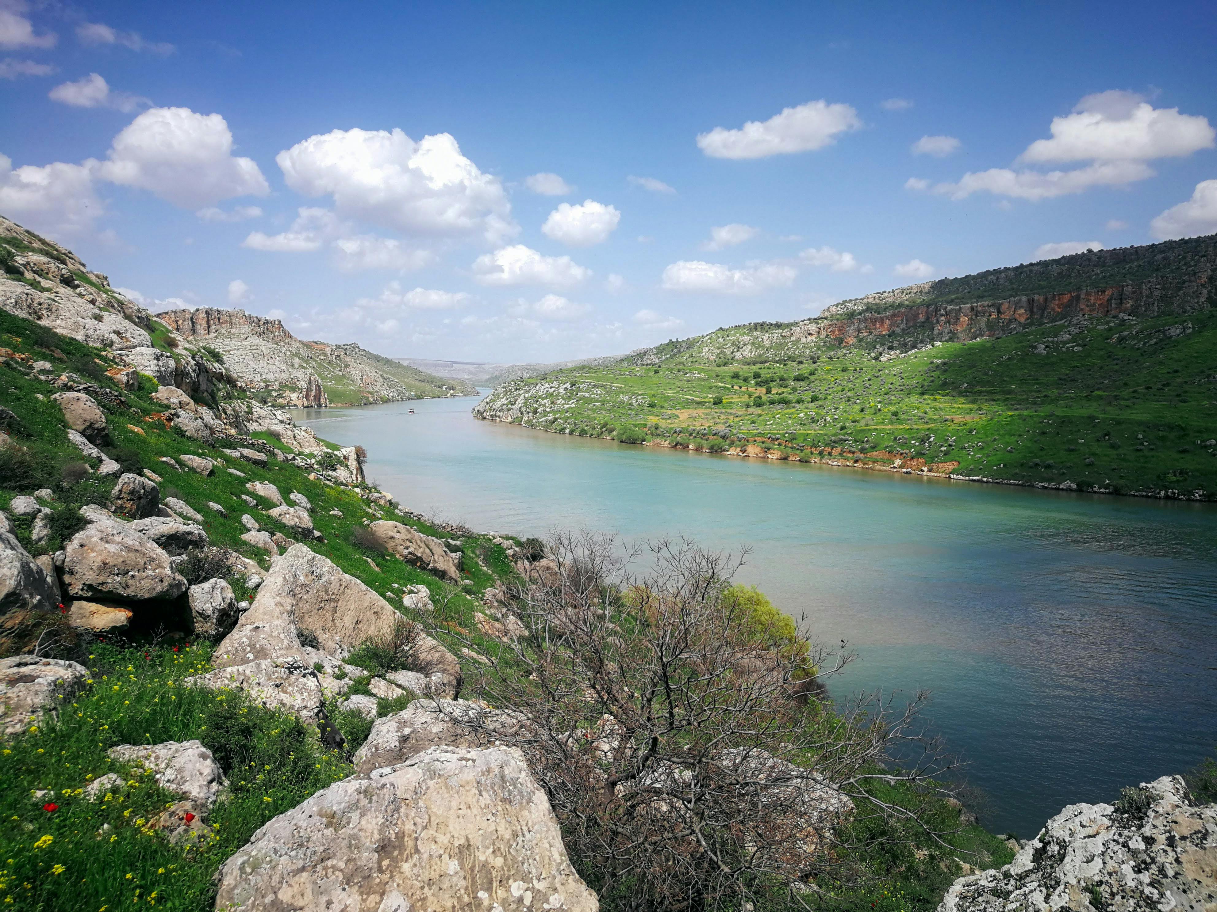 Body of Water in Between Rocky Mountains Under the Sky · Free Stock Photo