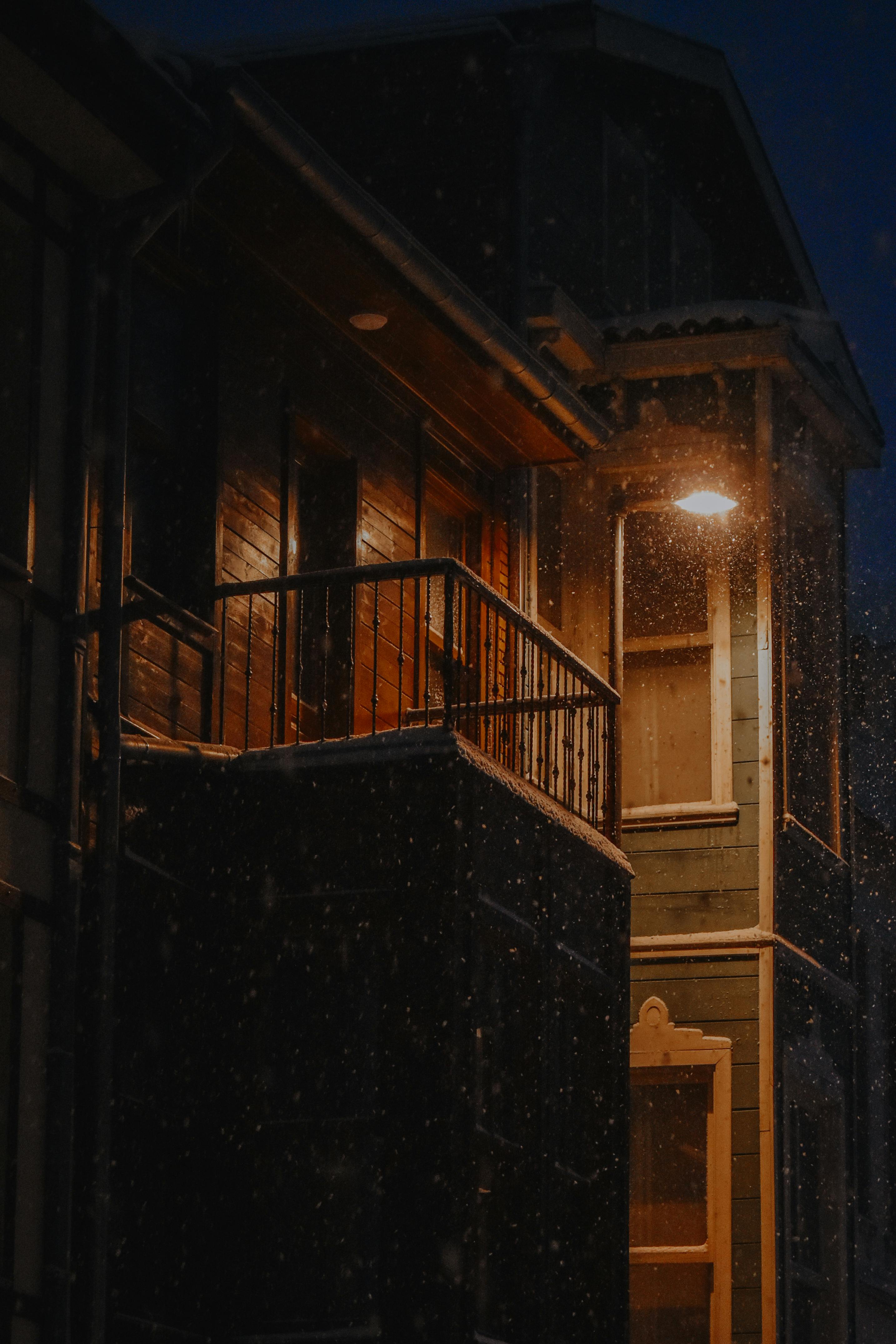Woman Standing on Balcony Watching Falling Snow · Free Stock Photo